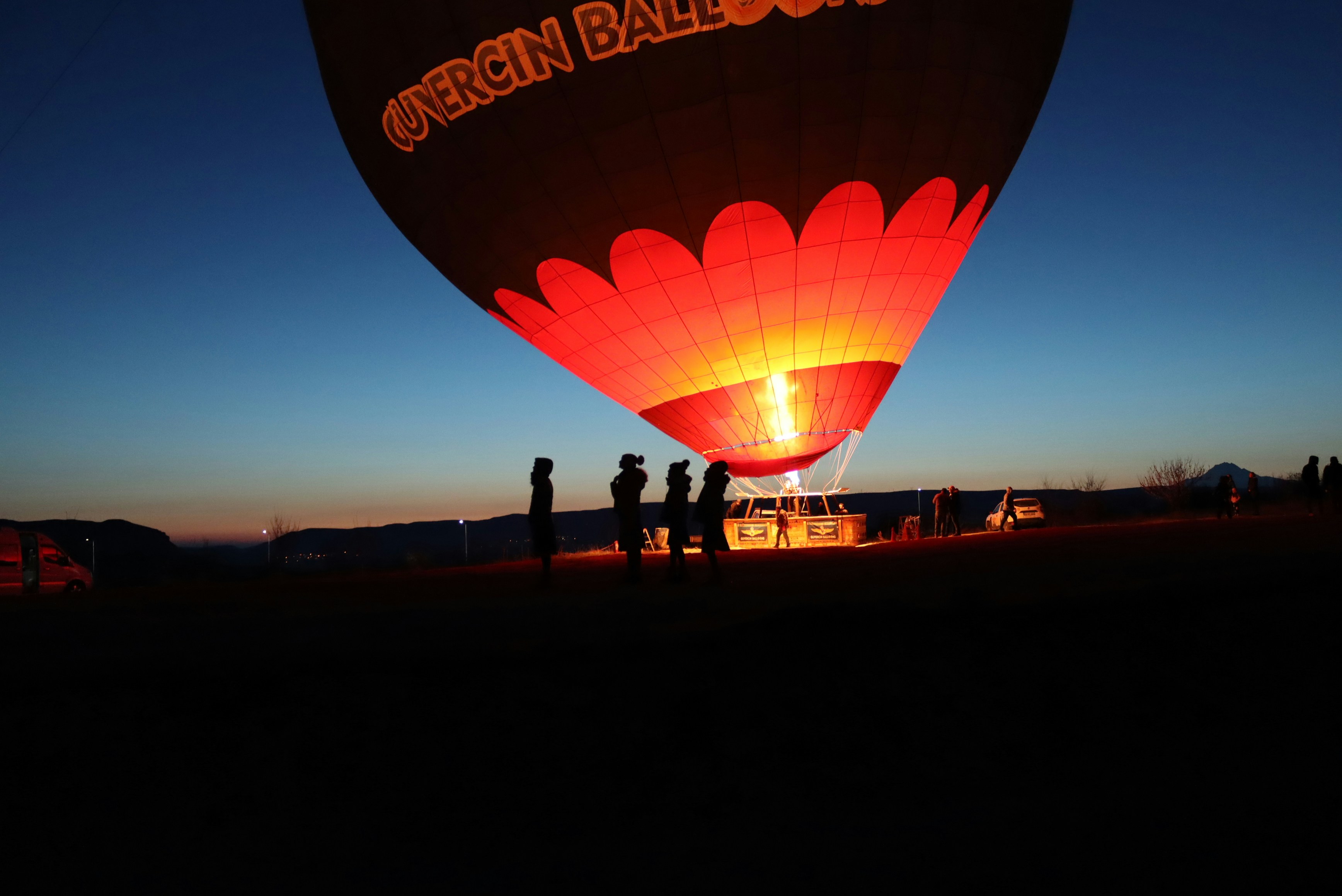 Dusk Ember Lift: Silhouettes Beneath a Crimson Balloon
