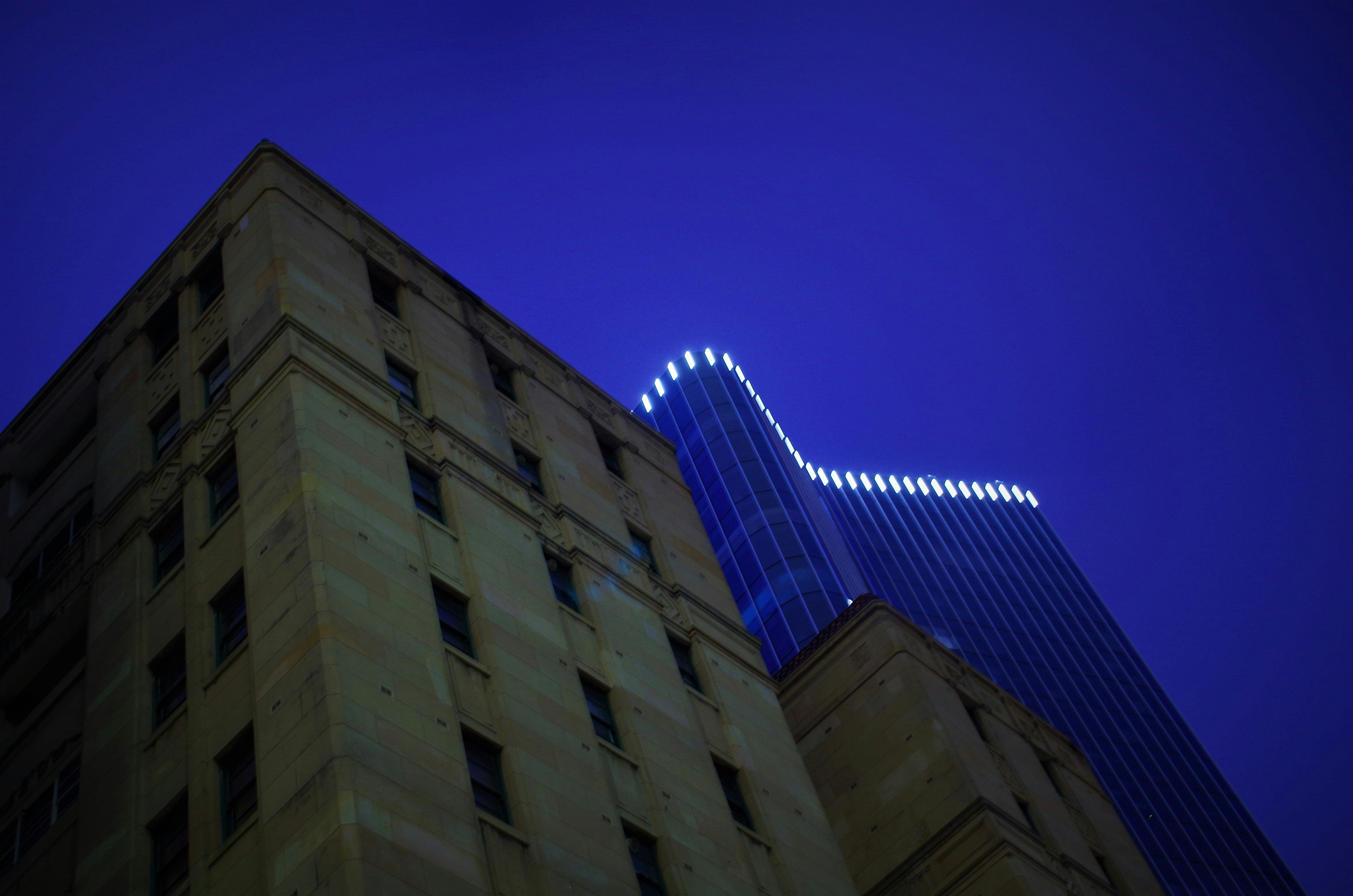 Neon Ribbon Summit: Blue Hour over Brutalist and Glass Skyscrapers