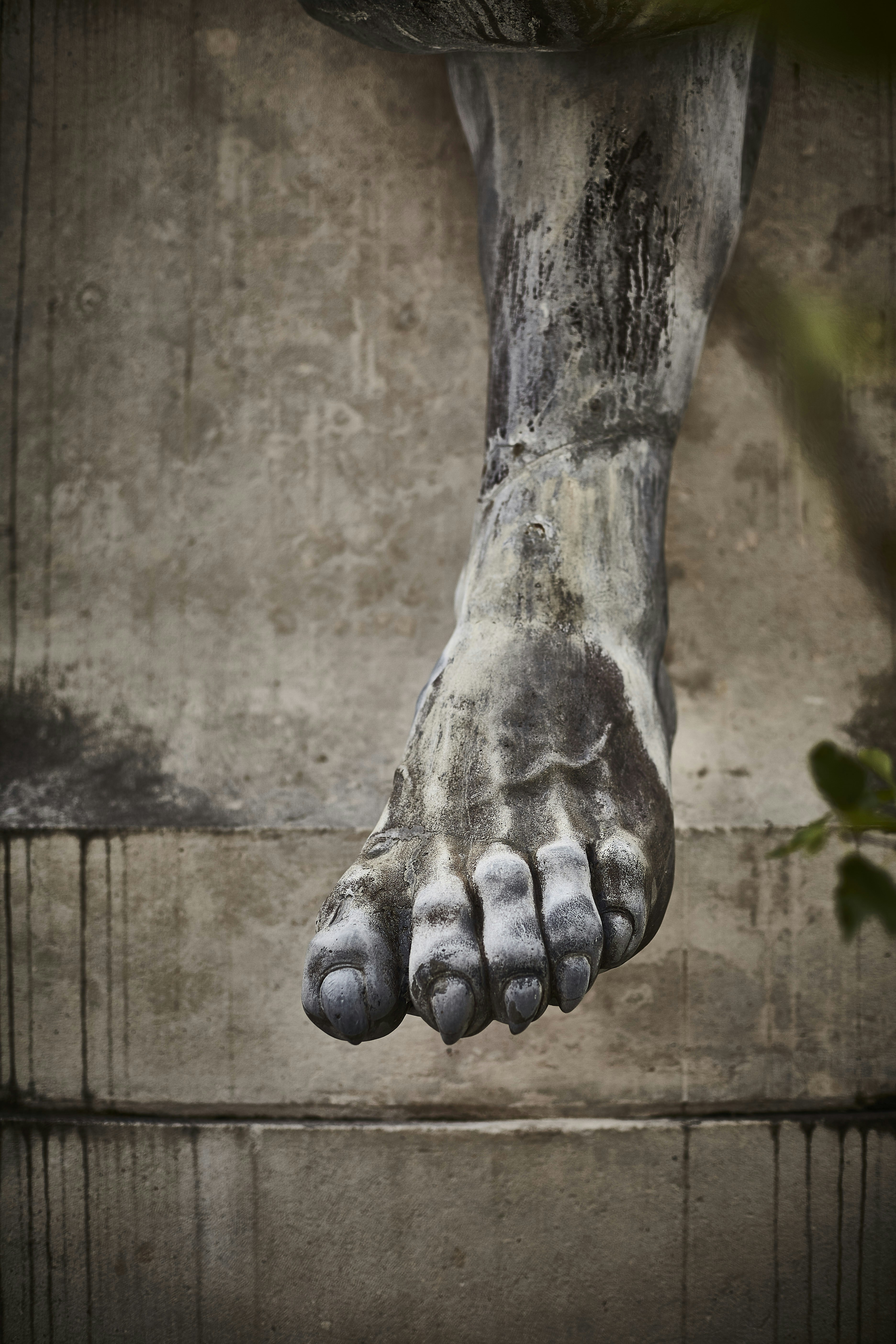 Dust-Covered Foot of a Weathered Monument Suspended Over Stone