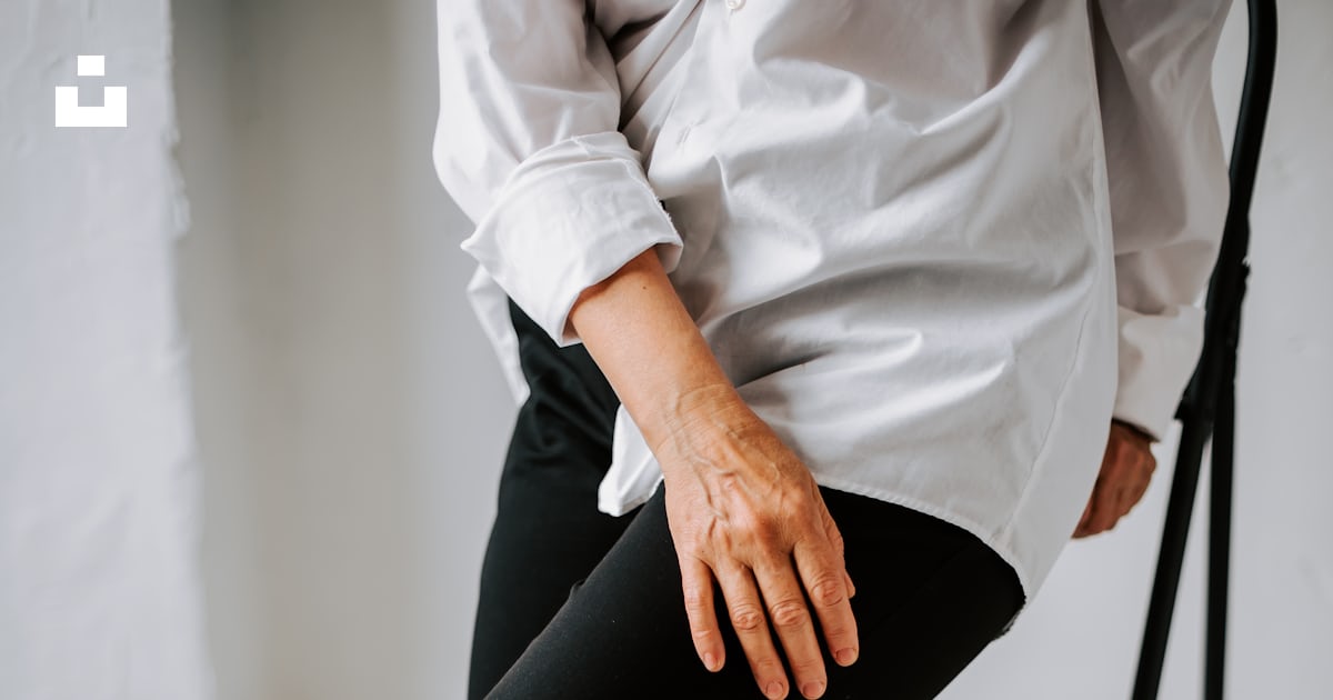 Une Femme Assise Sur Une Chaise Les Jambes Croisées Photo Photo Les