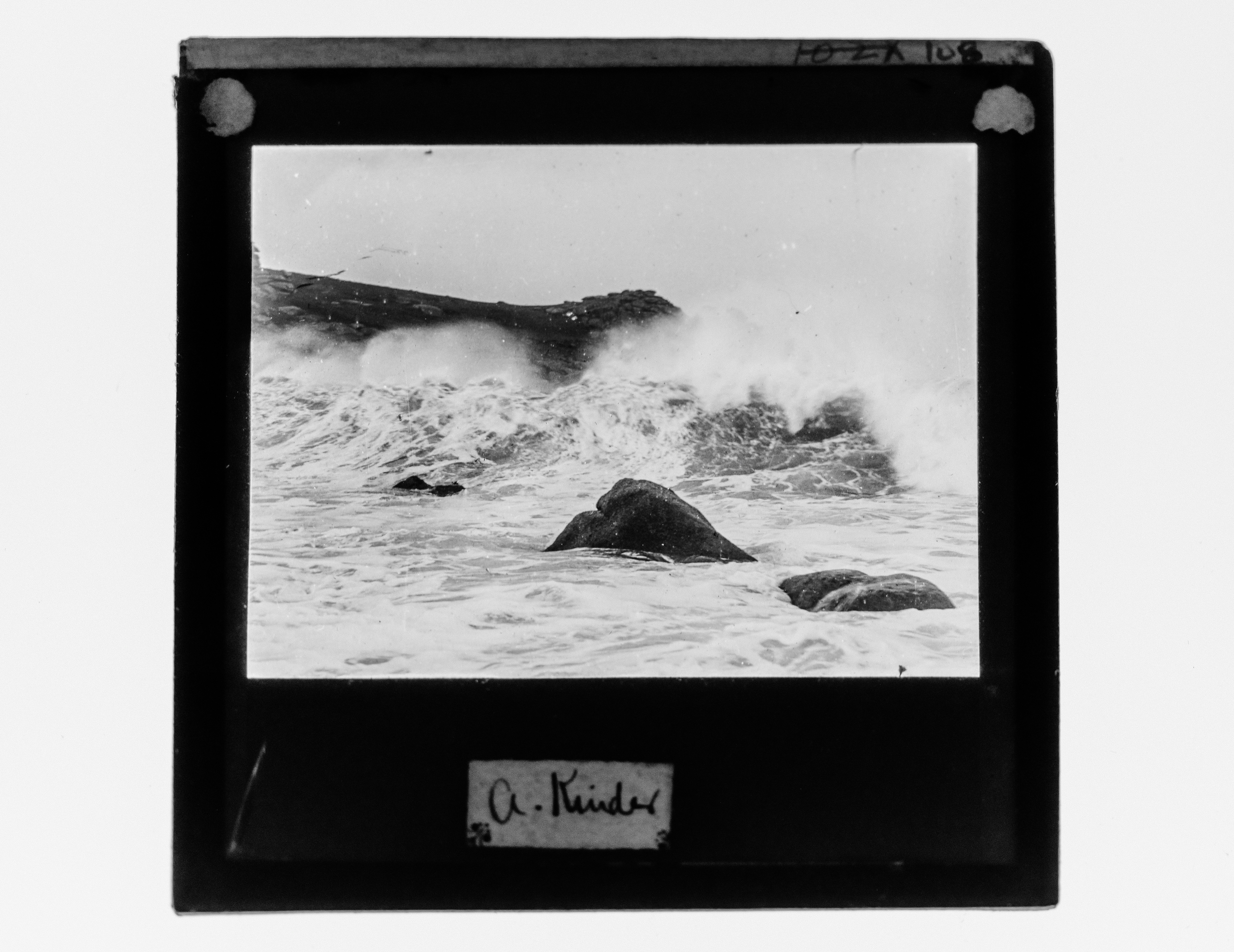 Foam Edge Over Jagged Rocks: A Framed Black-and-White Seascape