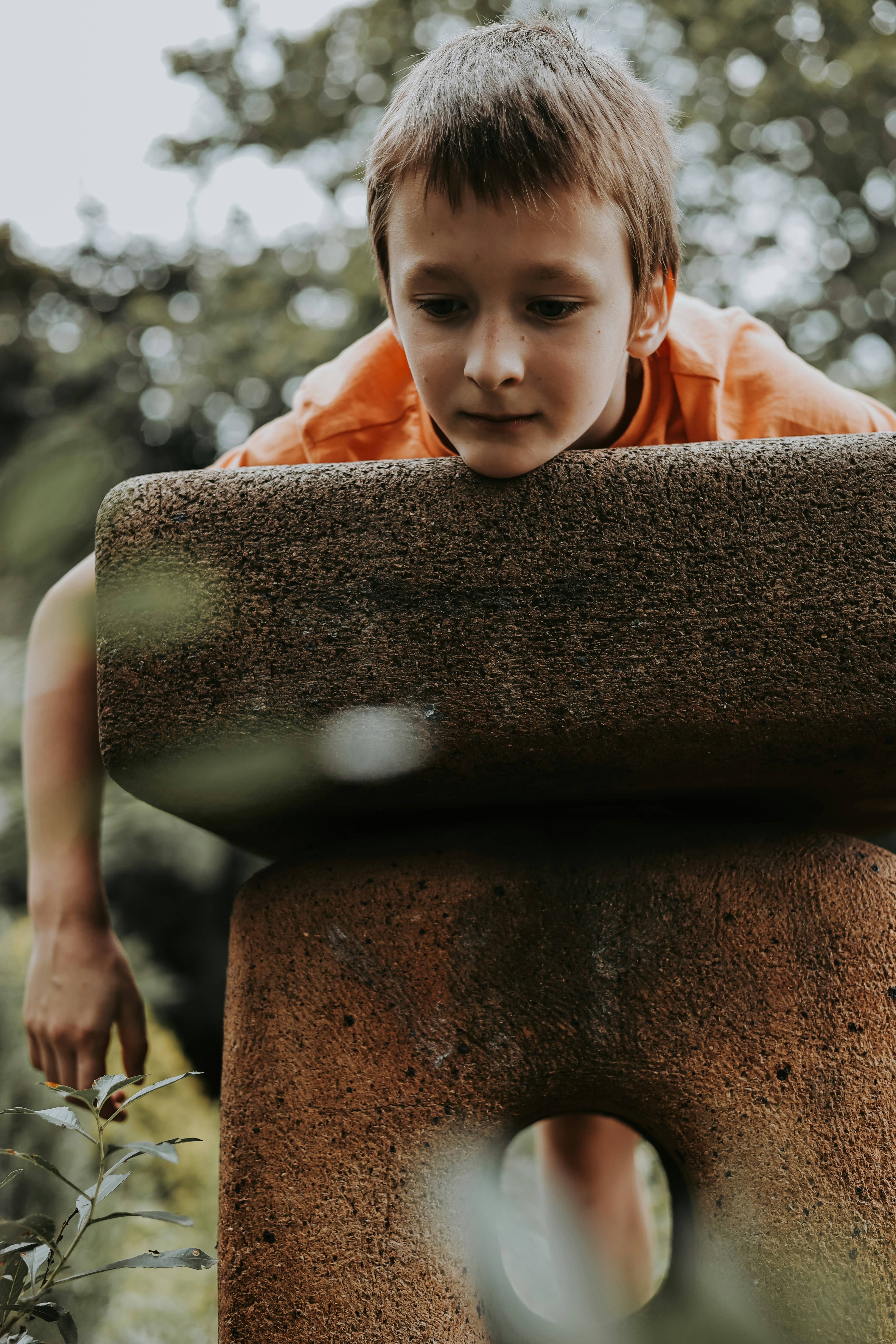 A young boy leaning over a stone structure photo – Free Margitsziget ...