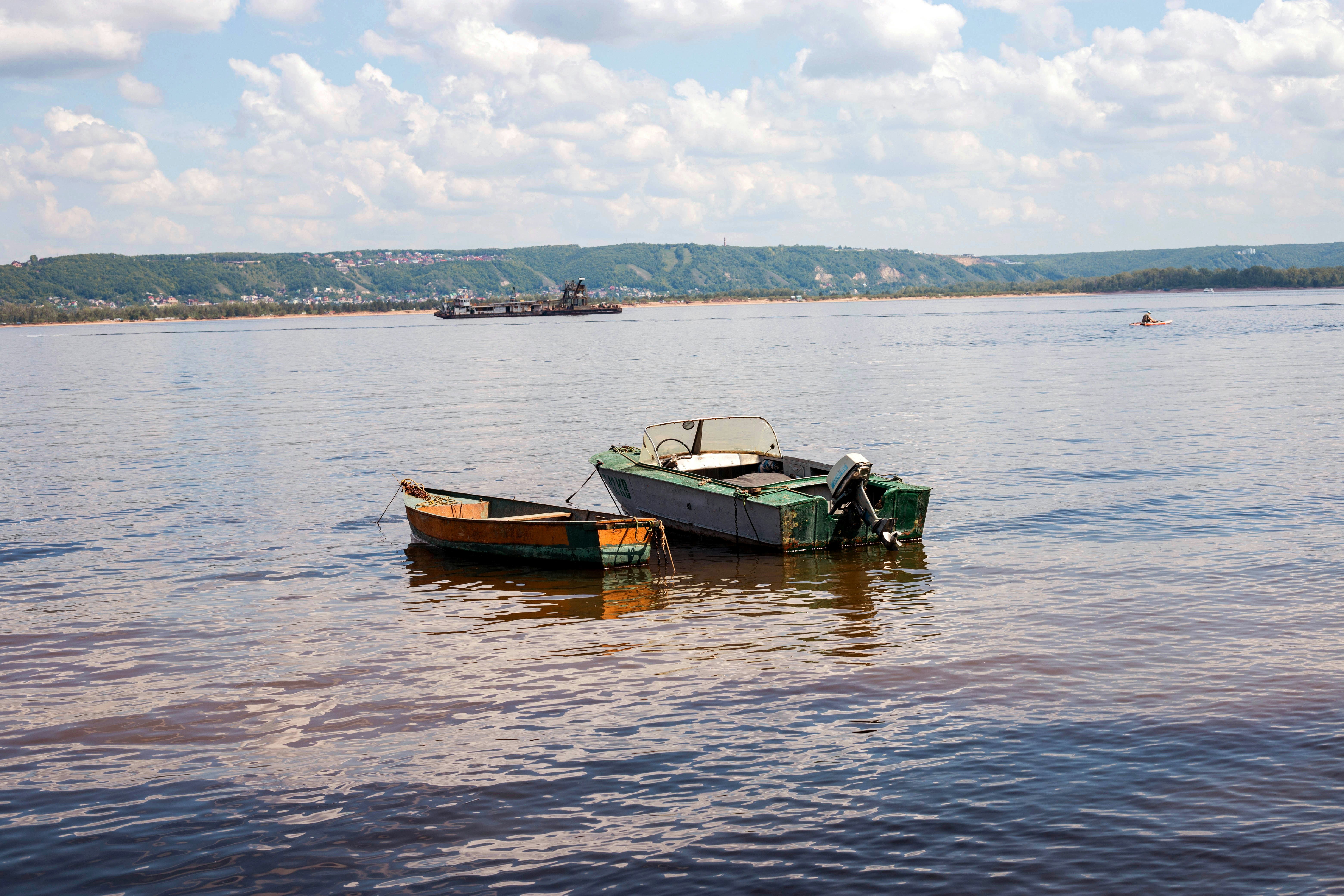 A couple of small boats floating on top of a lake photo – Free Summer ...