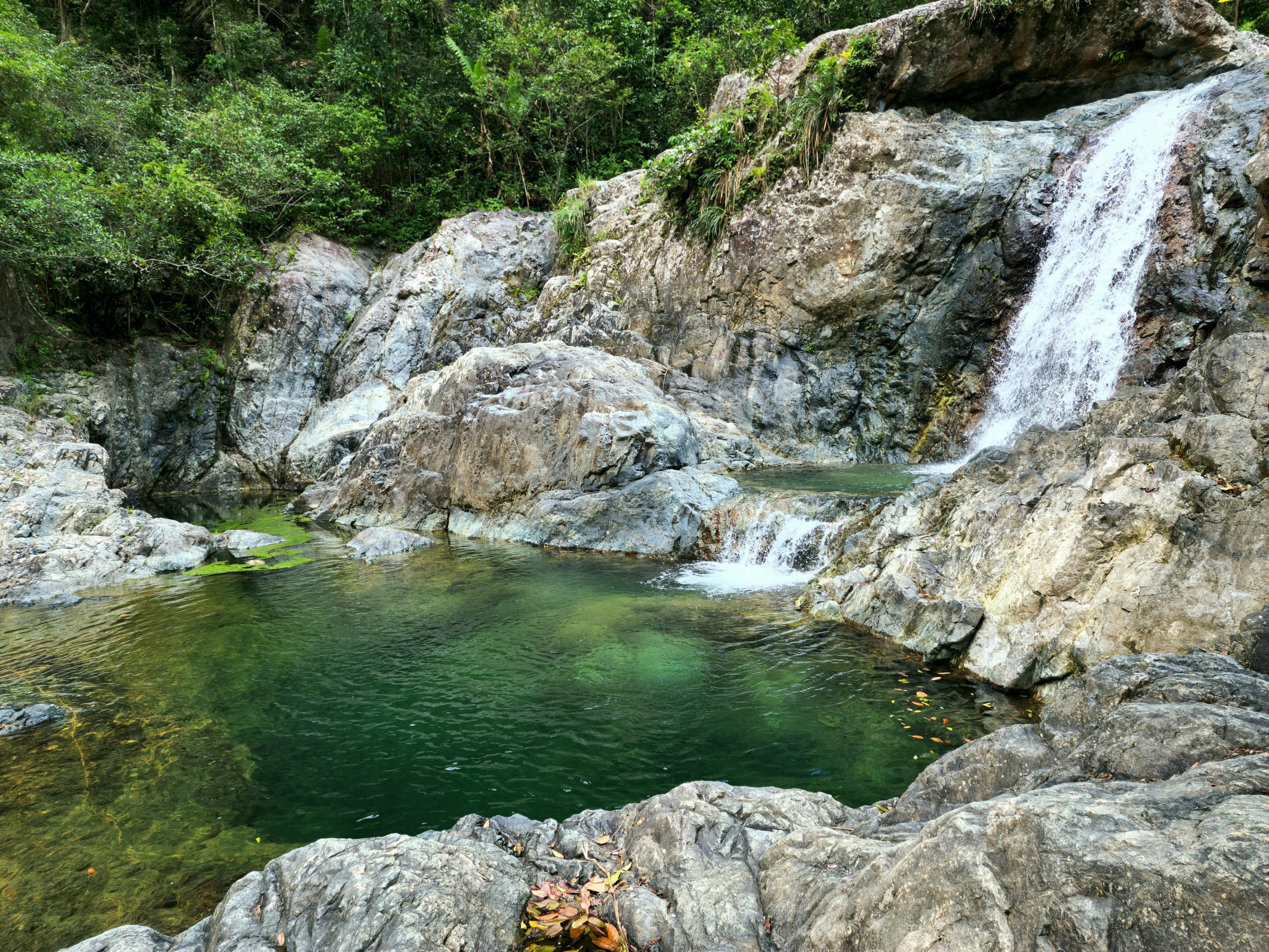 A small pool of water surrounded by large rocks photo – Free River ...