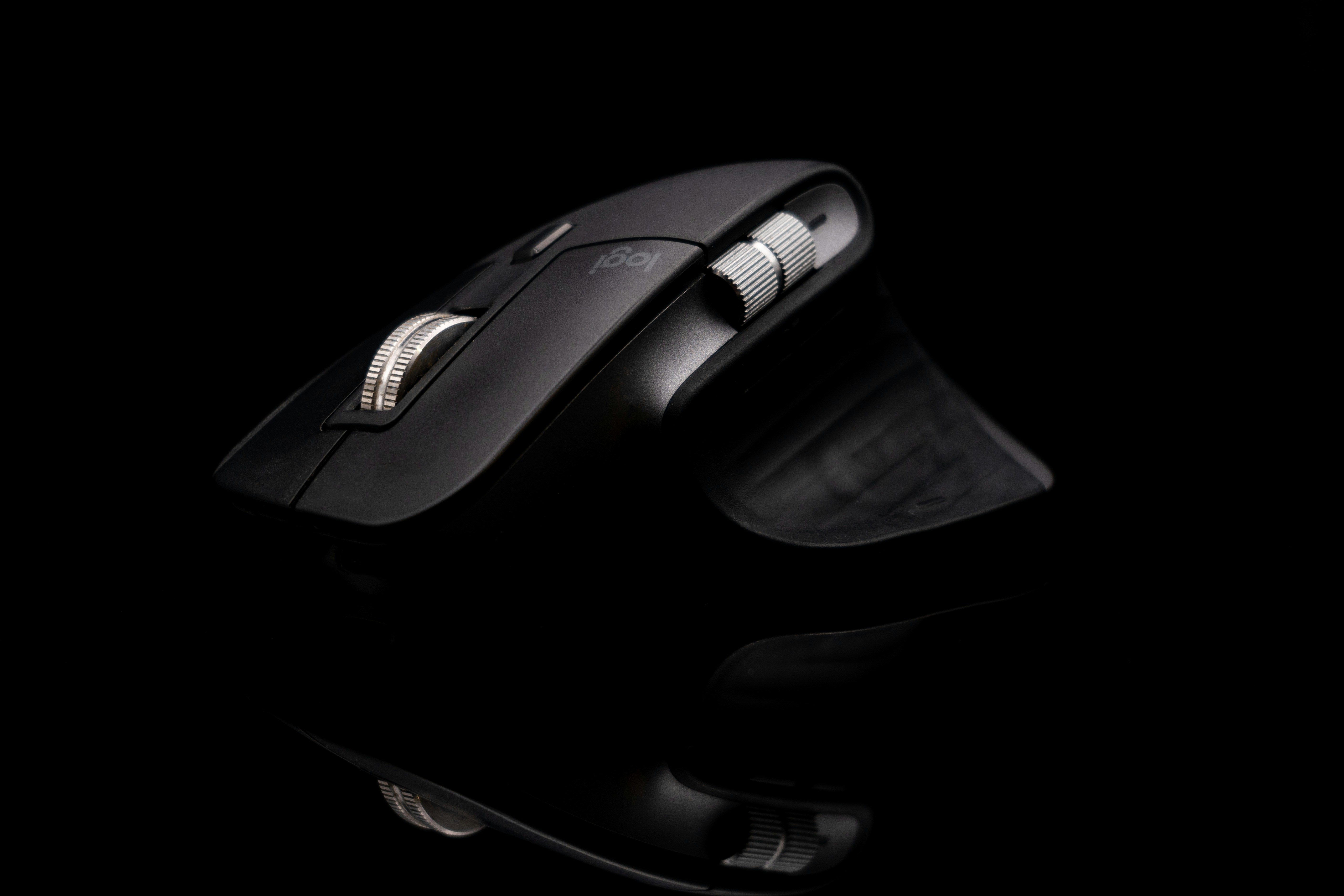 A computer mouse sitting on top of a black surface photo – Free Apple ...