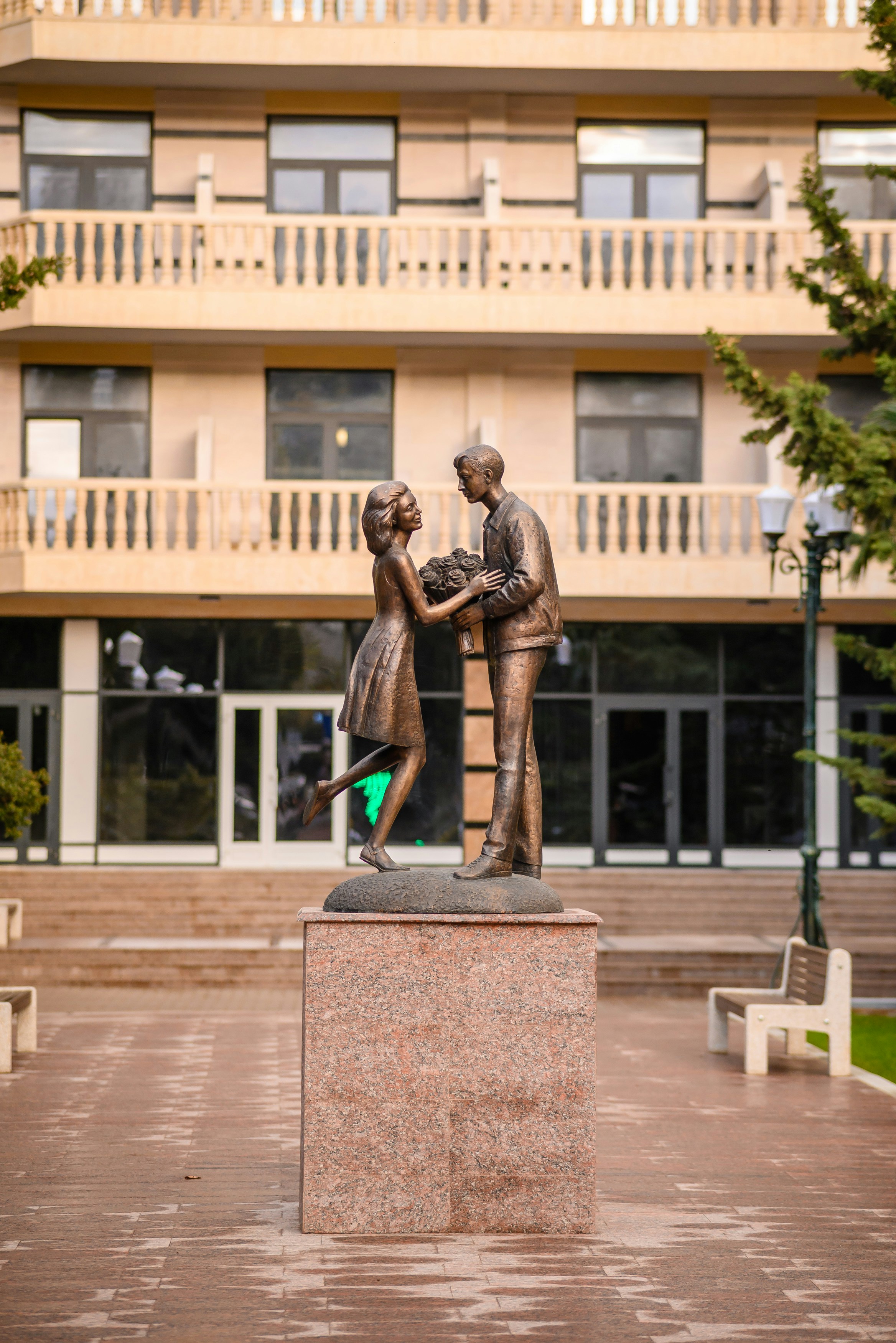 A statue of two people shaking hands in front of a building photo ...