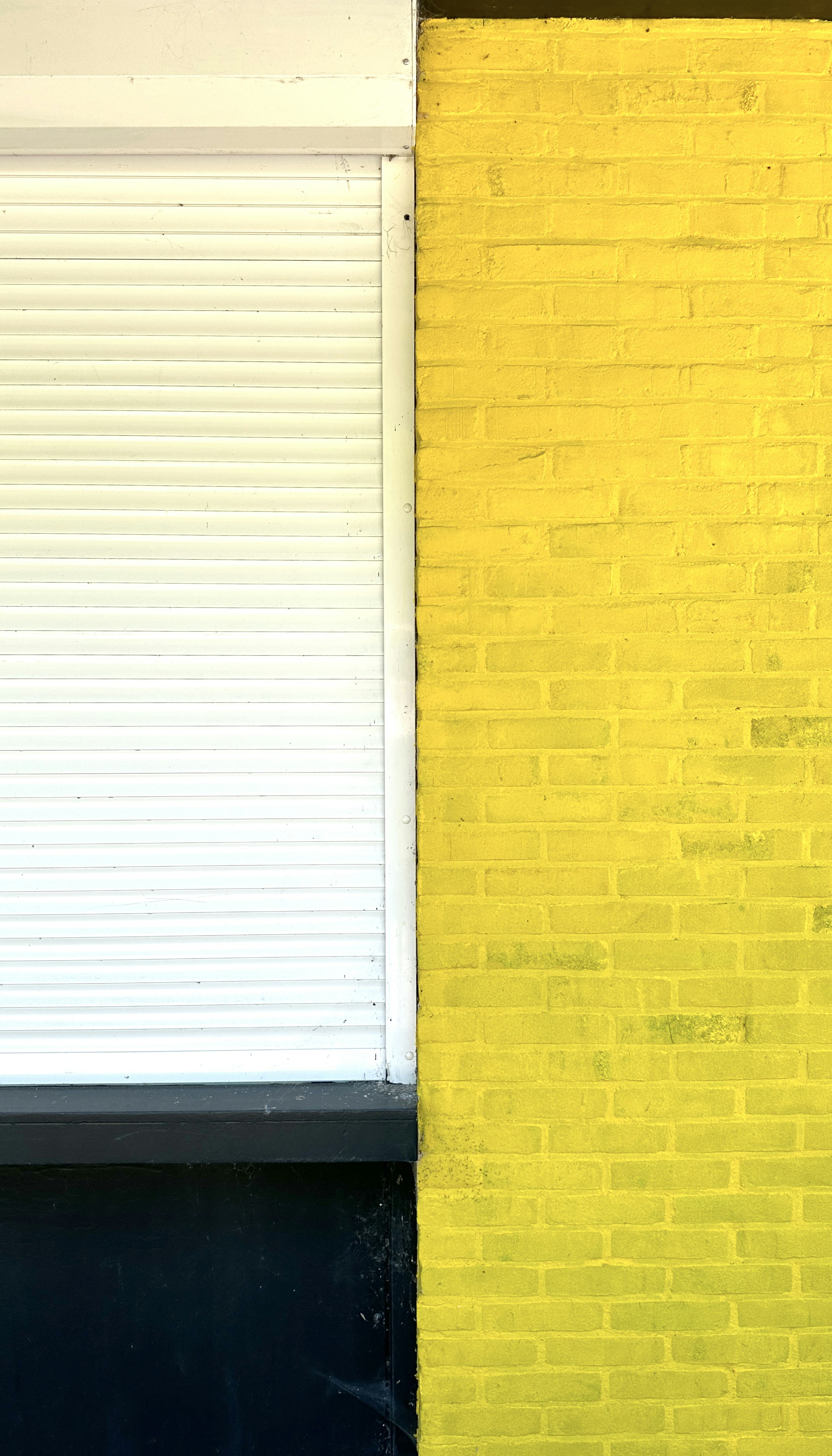 A yellow and black building with a clock on it's side photo – Free Home ...