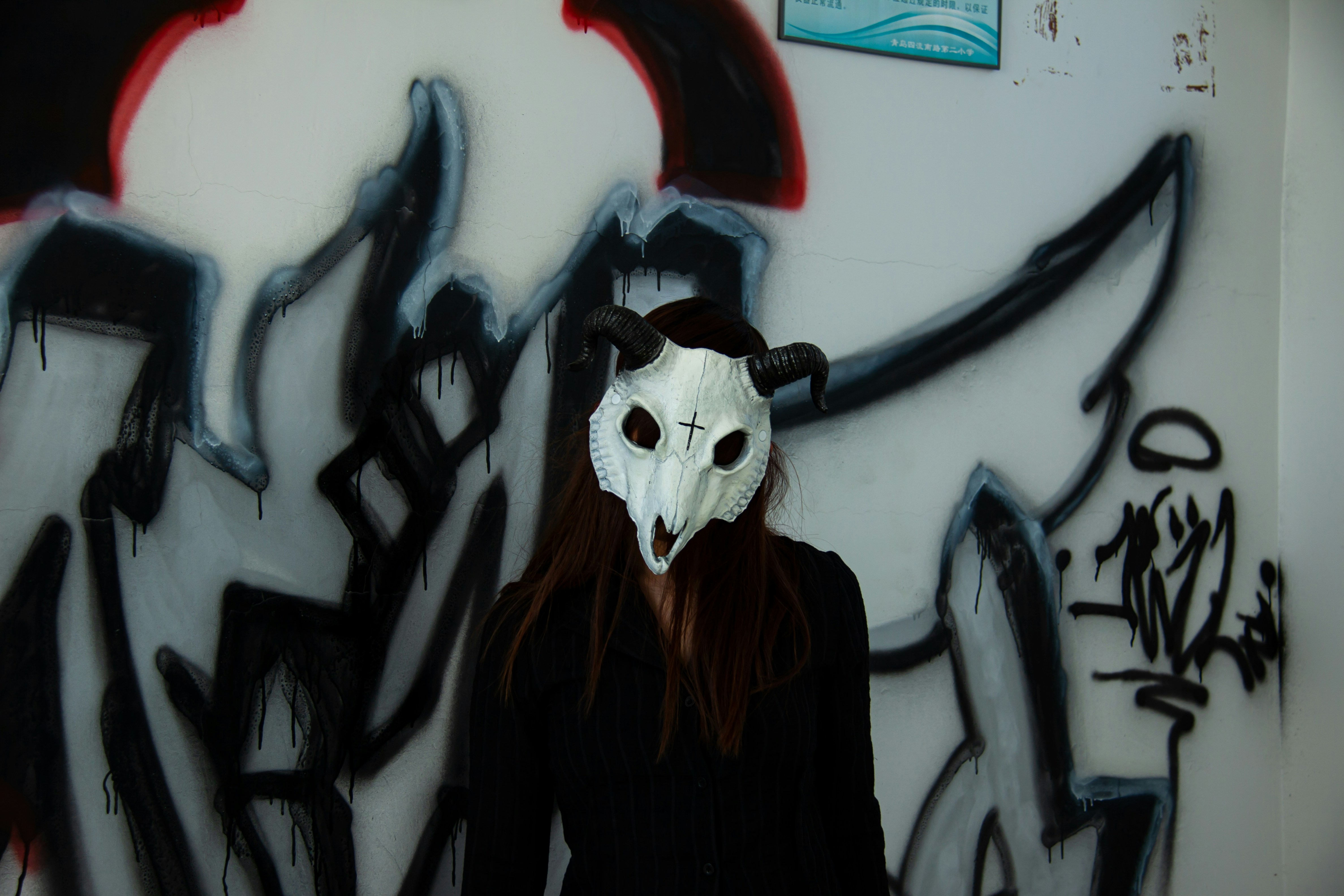 Horned Skull Mask Before a Graffiti-Painted Wall