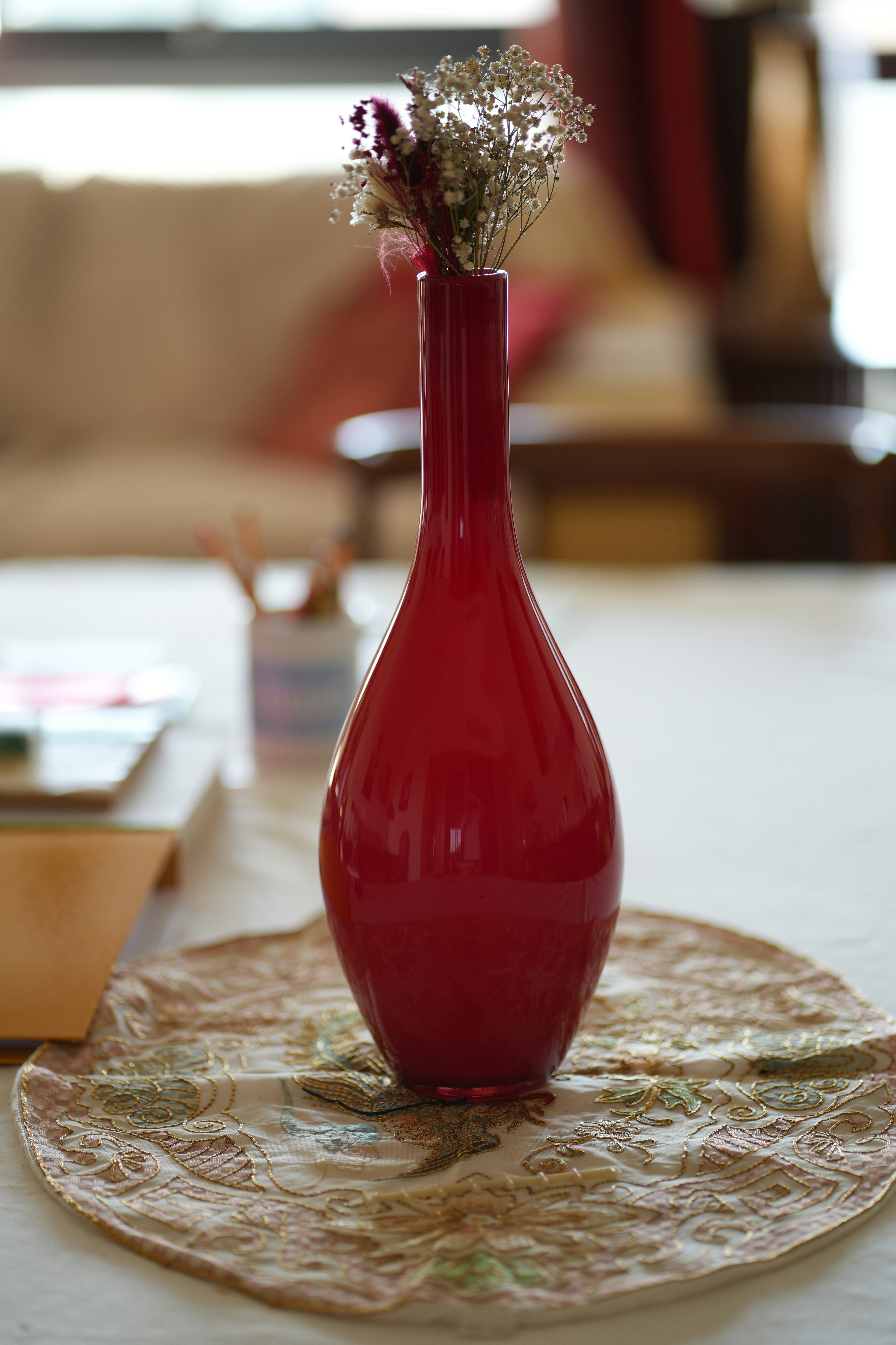 Crimson Vessel on Lace: A Quiet Tabletop Moment
