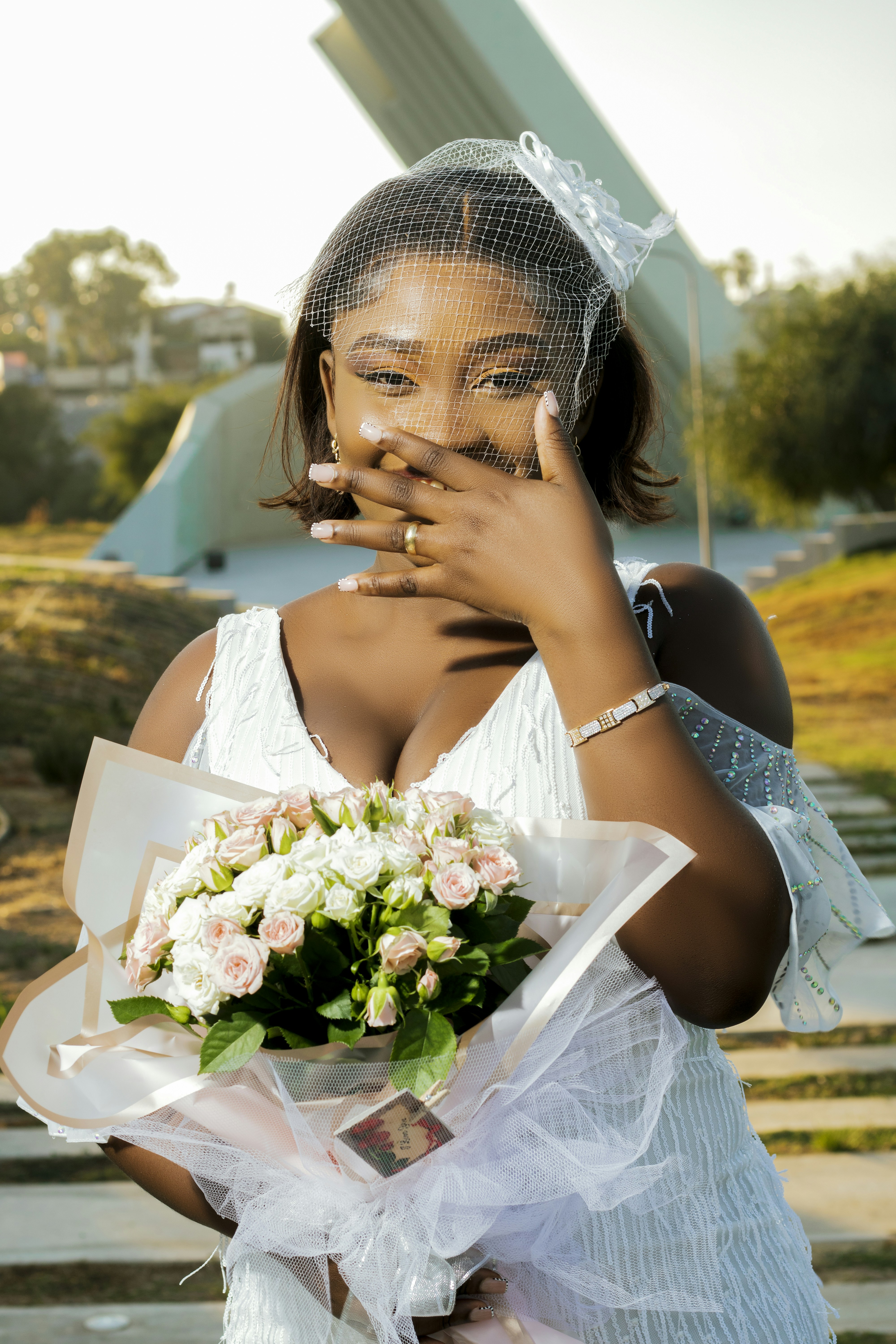 Veil Over Joy: Bride Holds a Blush Bouquet Before a Modern Arch