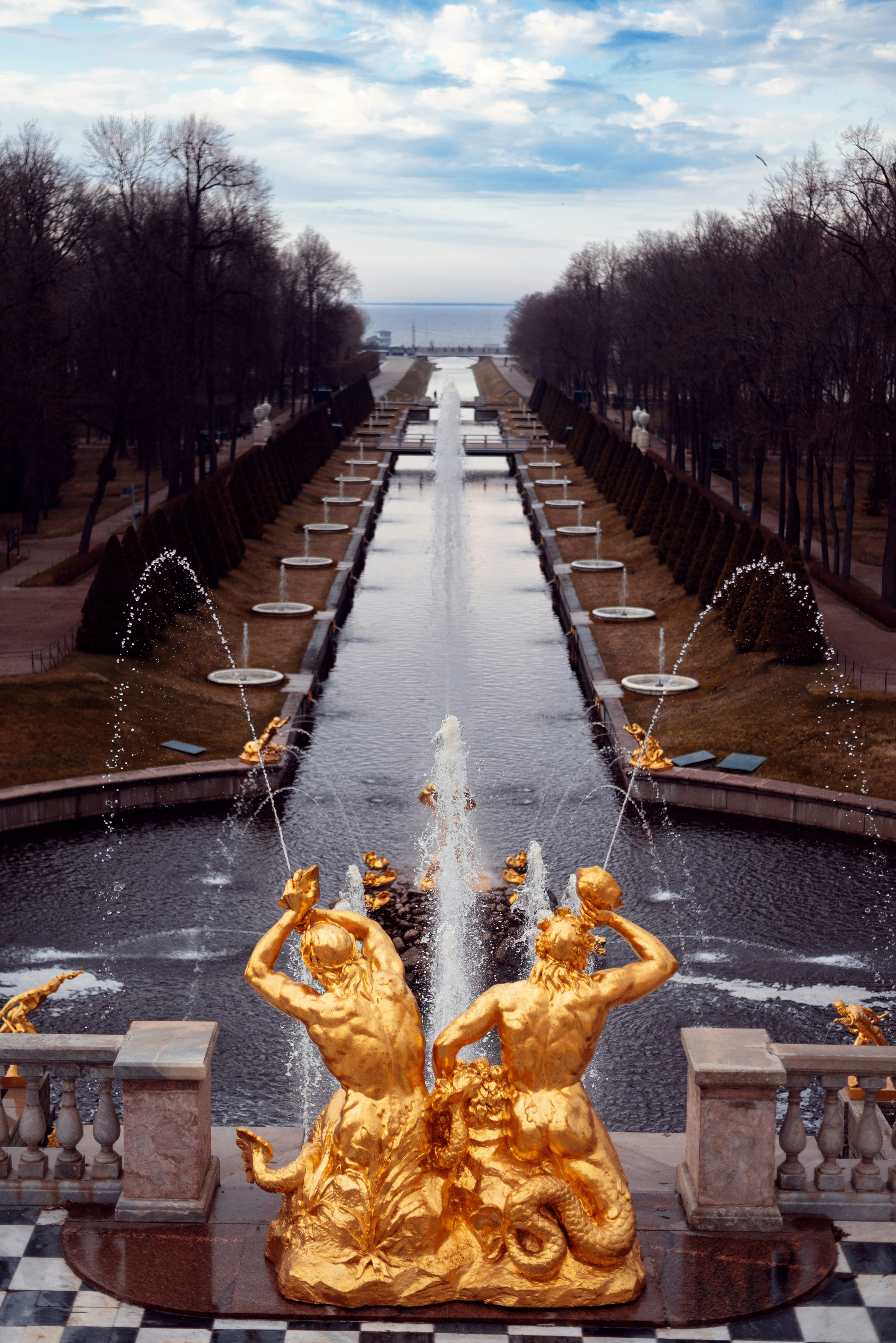 Gilded Statues Framing a Symmetrical Canal Toward the Sea