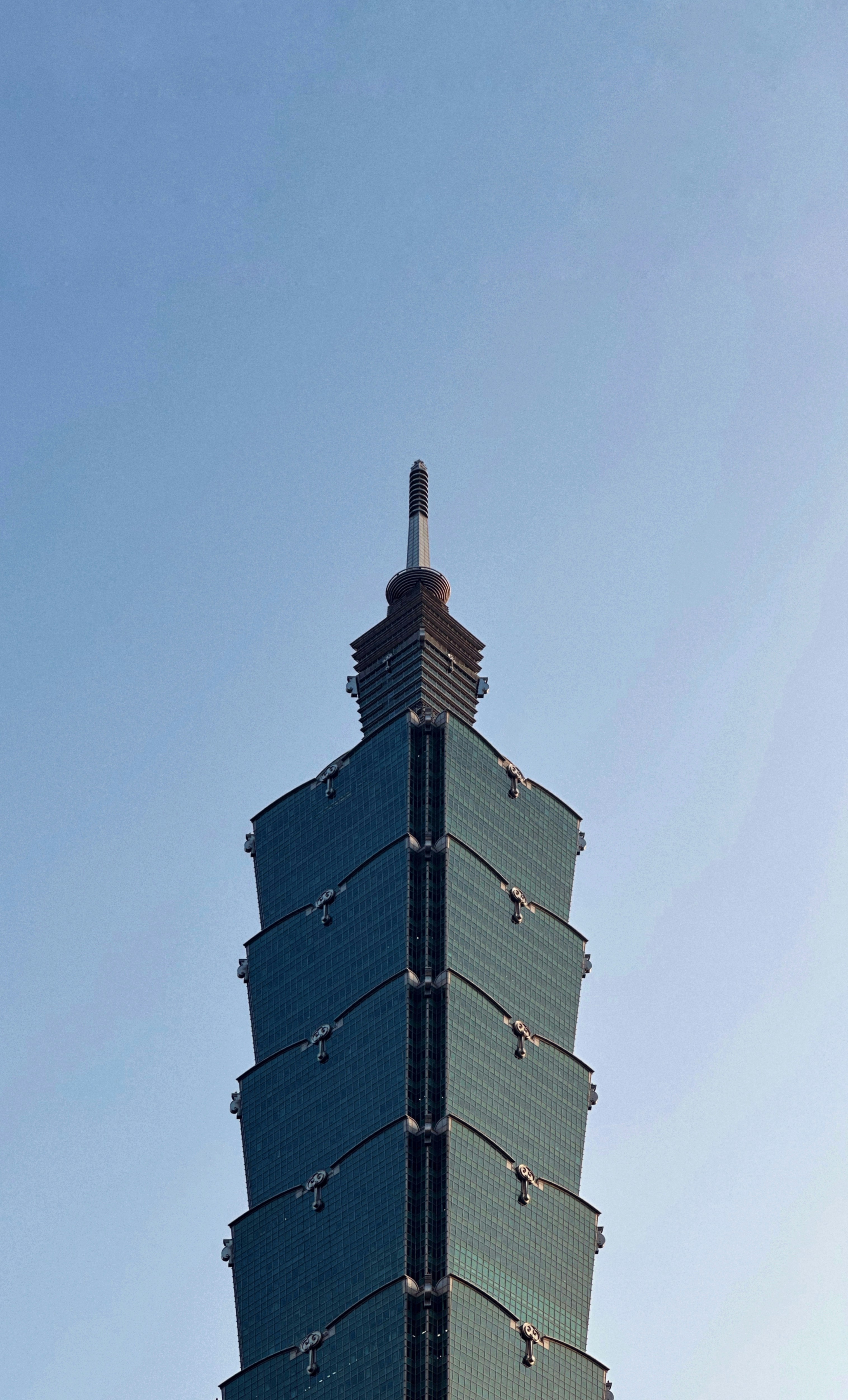 Tiered Summit Under a Cloudless Sky: Close-Up of a Tower’s Crown