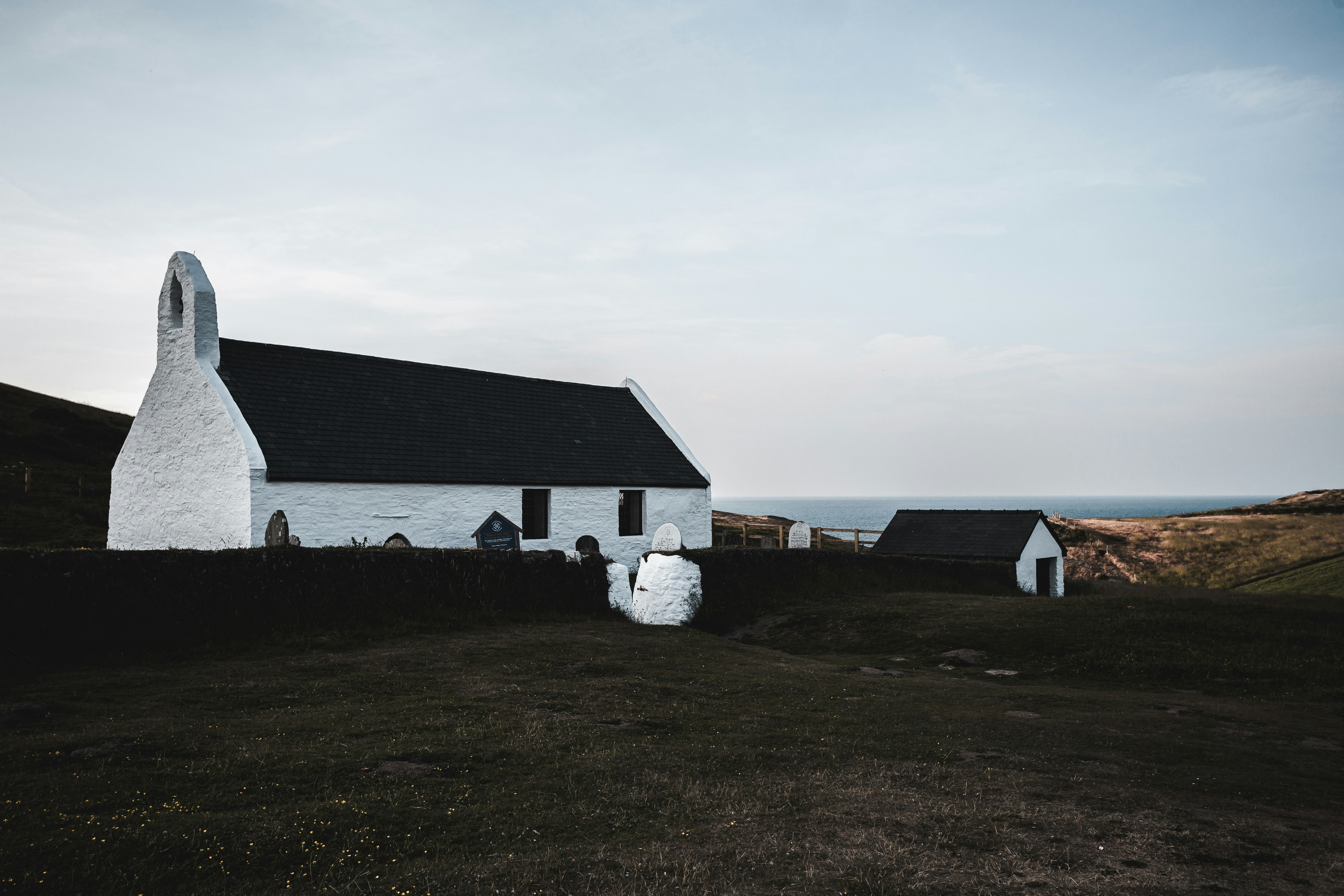 A white church with a black roof on a hill photo – Free Mwnt Image on ...