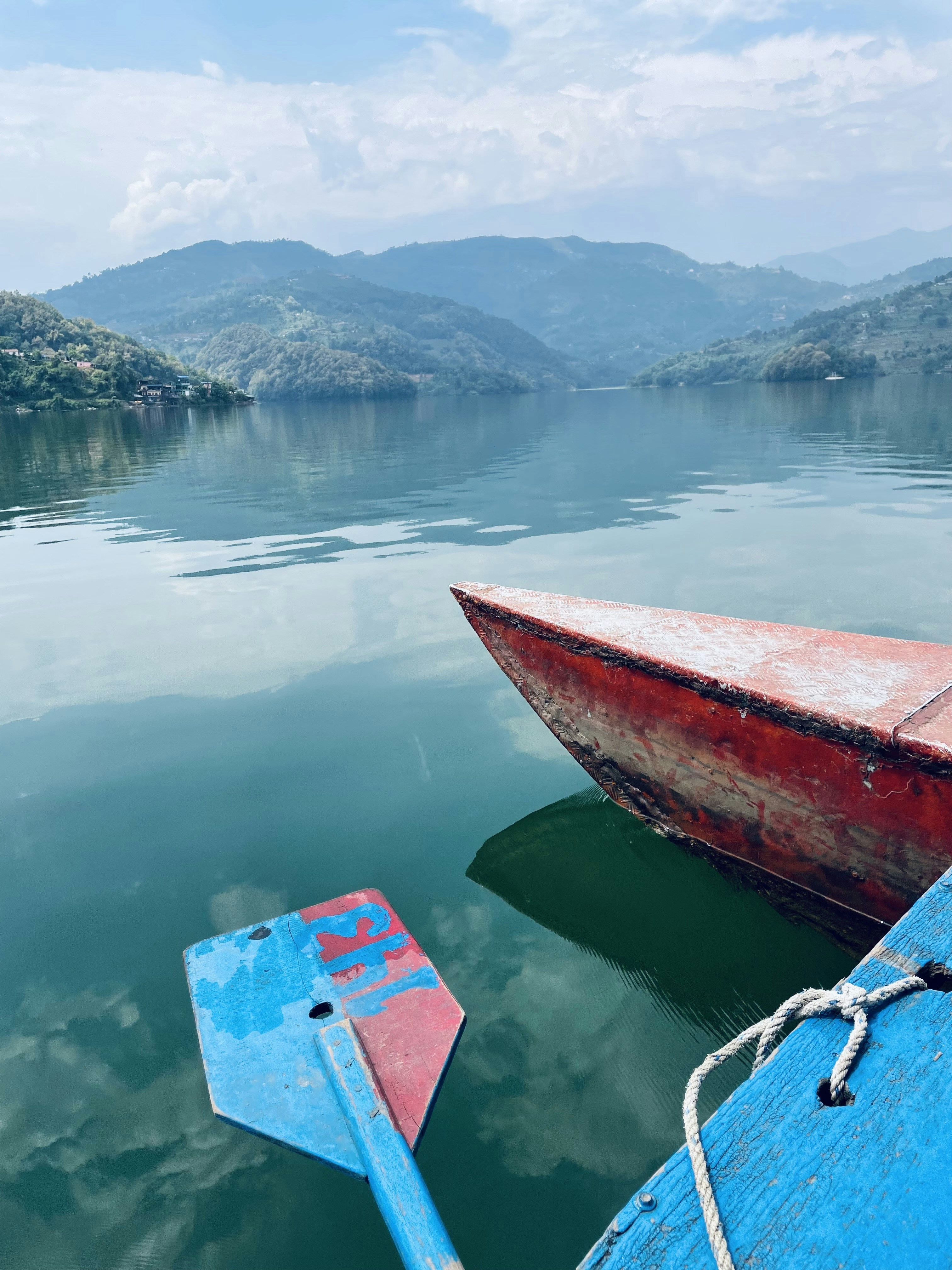Red Bow at the Lake: A Quiet Boat Scene Framed by Mountain Reflections