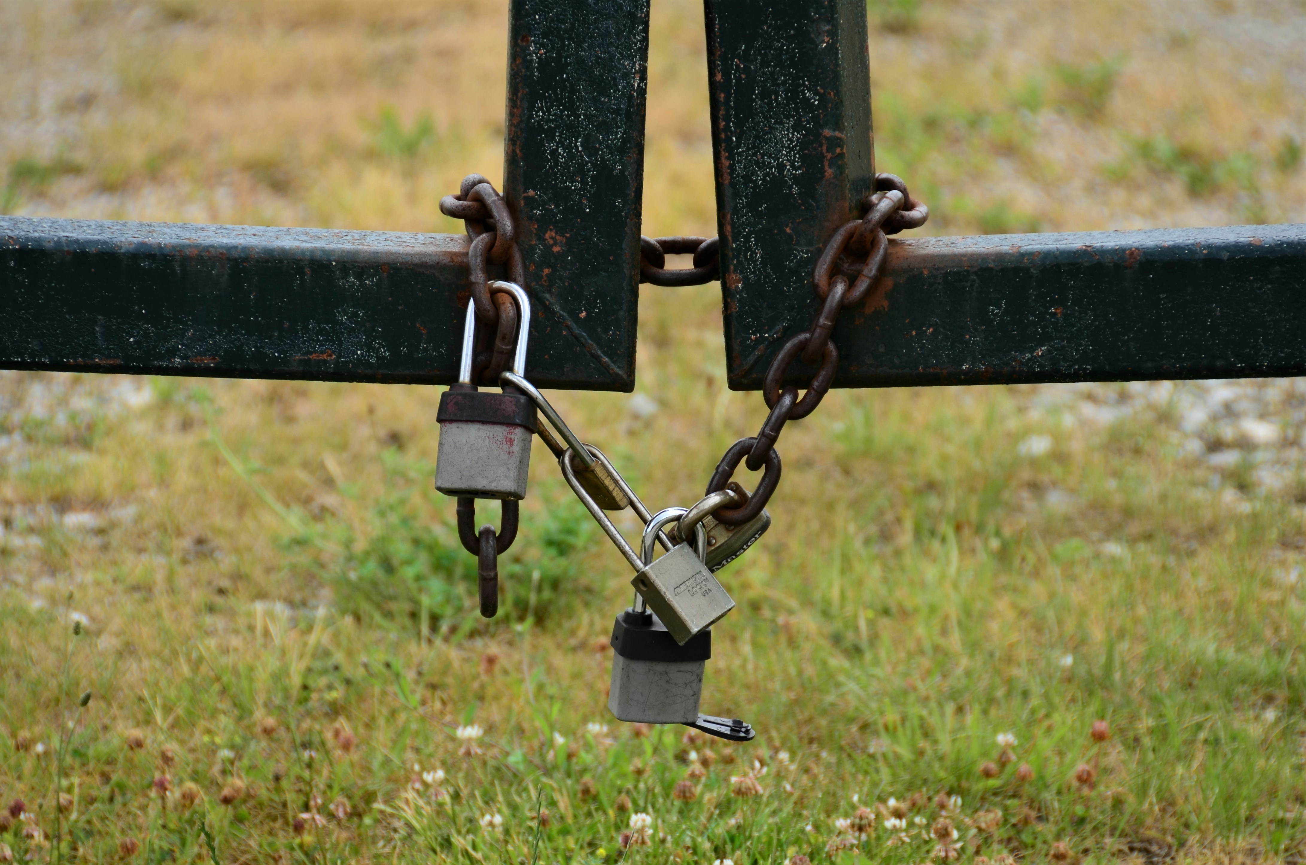Two Padlocks, One Gate: Rusted Chains Guard a Quiet Field