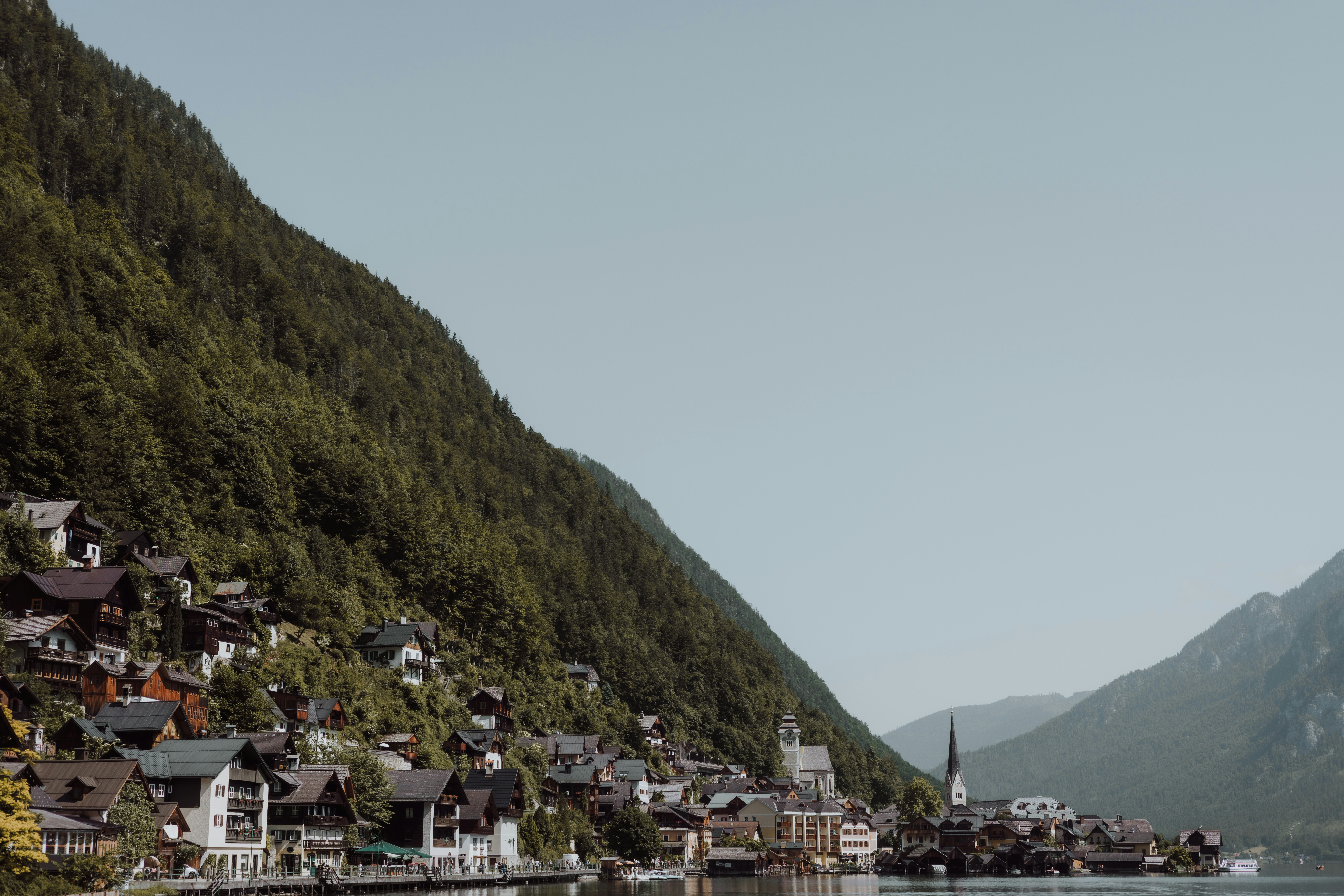 A small village on the side of a mountain next to a body of water photo ...