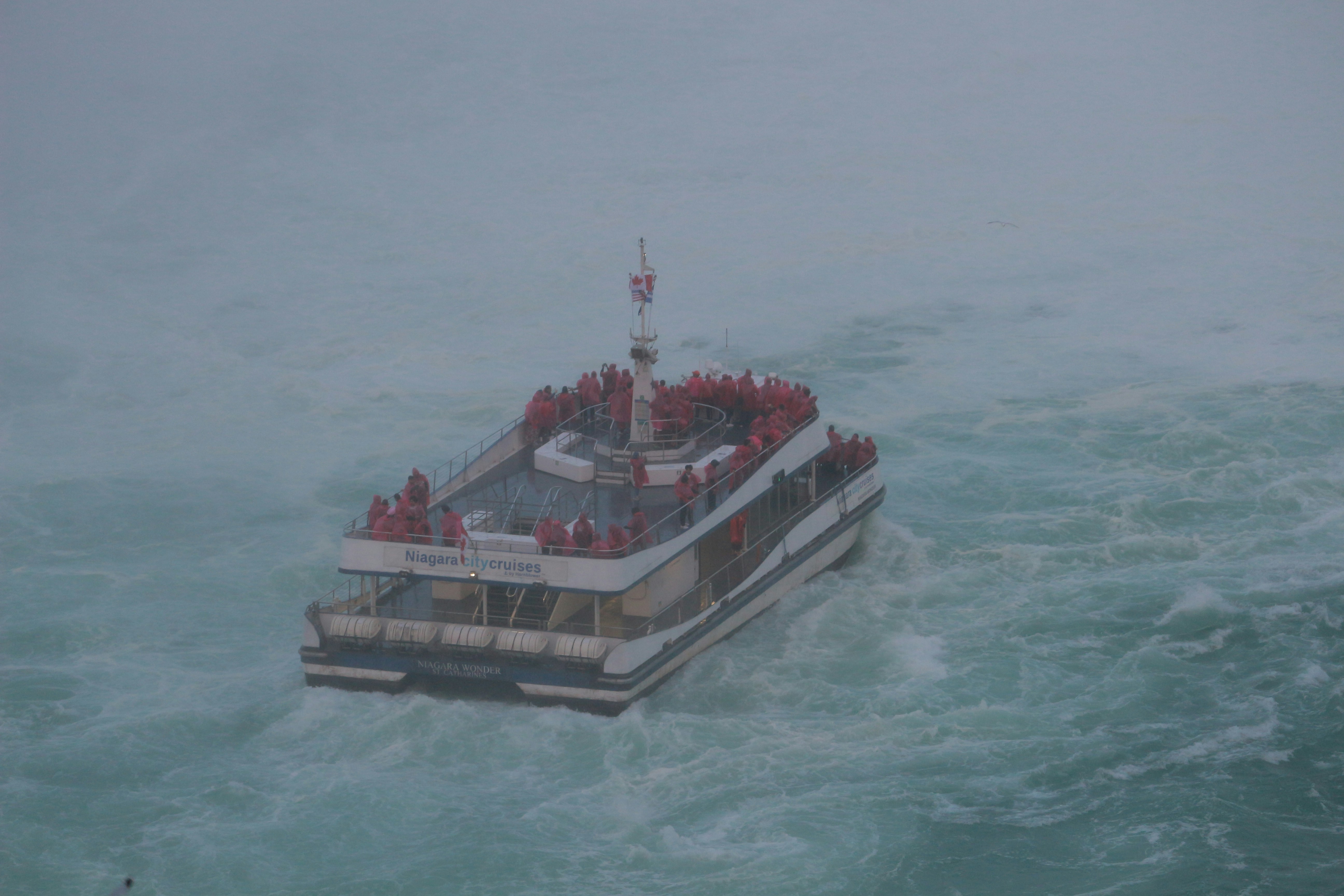 Mist-Clad Tour Boat Ribbons Through Emerald Swells