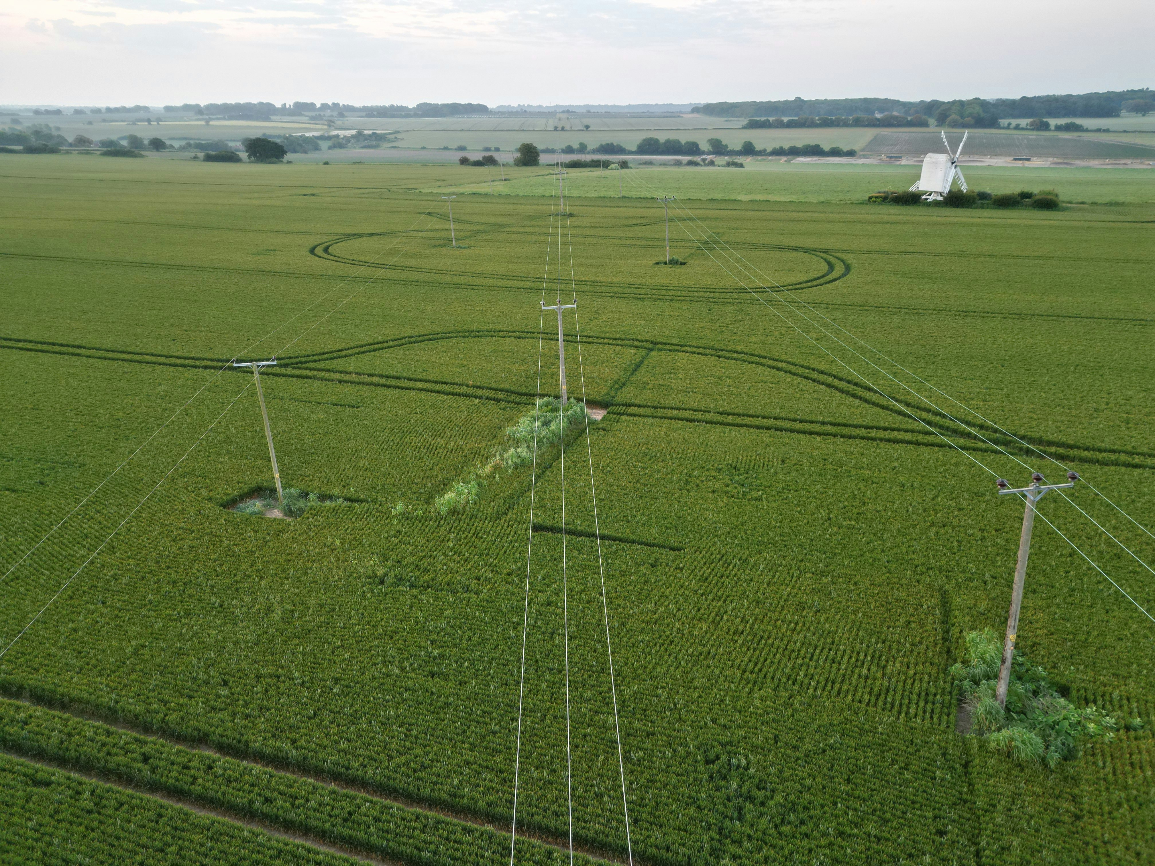 Aerial shot showing Chillenden Windmill alongside telegraph poles with cables going into the distance