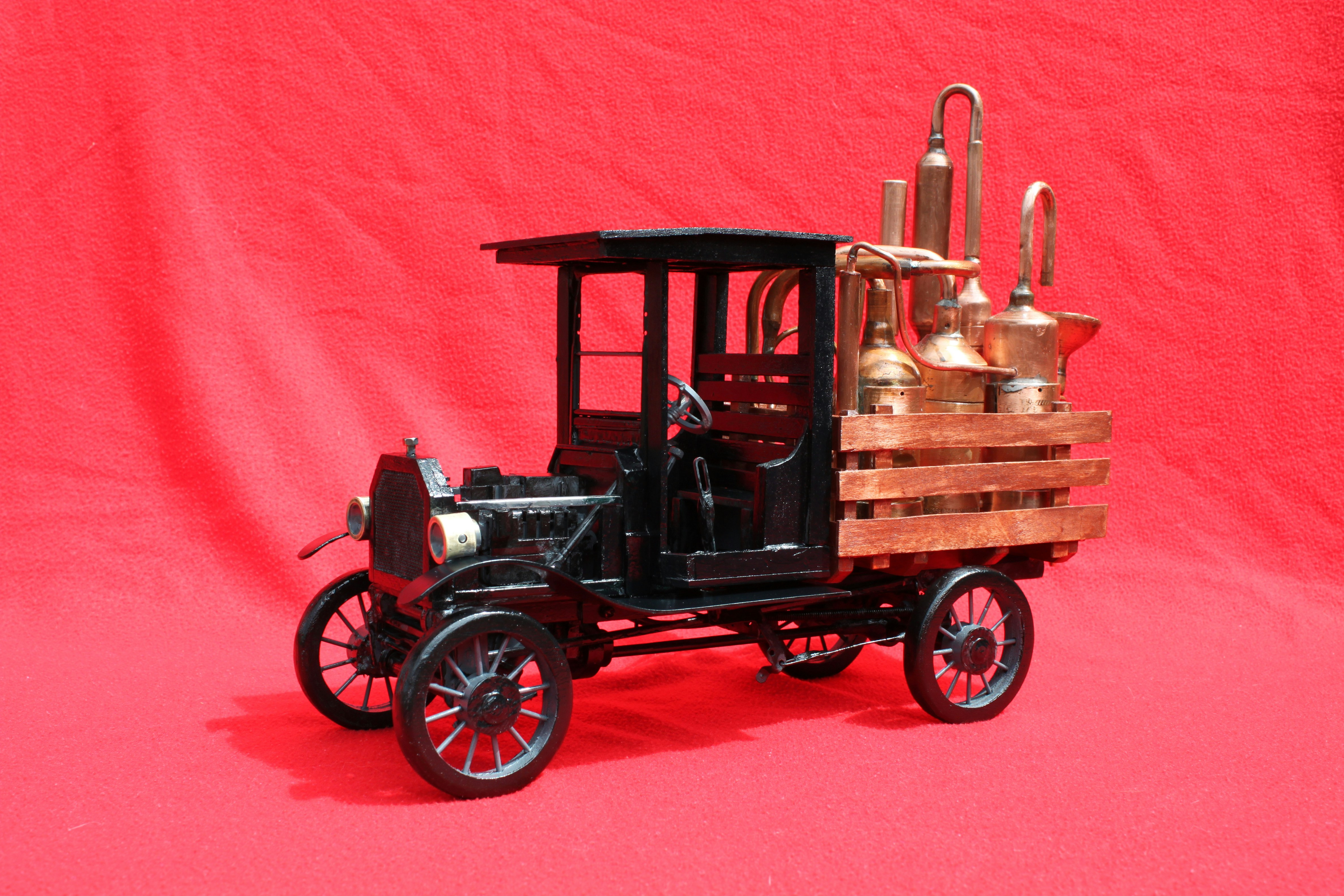 an old model car with a bunch of brass items on it