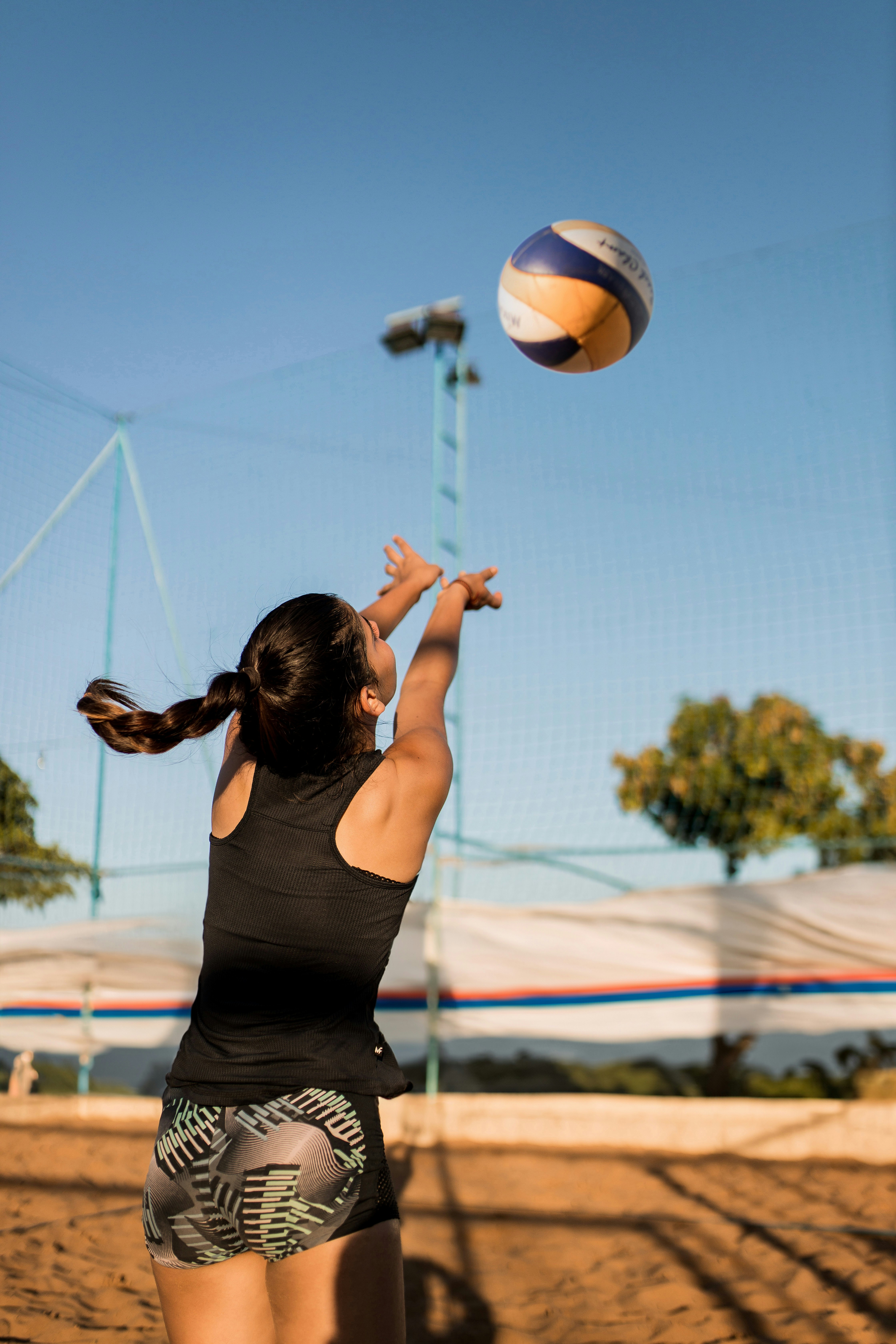 A woman reaching up to hit a volleyball photo – Free Shorts Image on ...