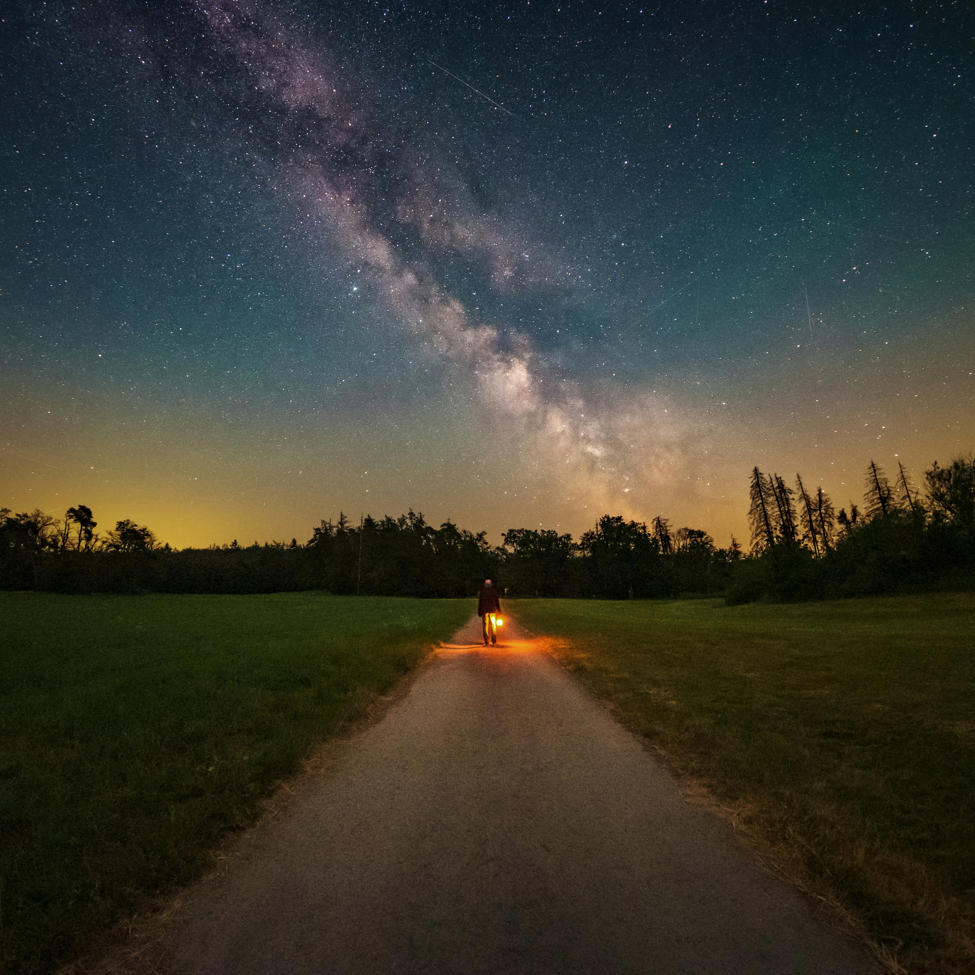 Lantern on the Milky Way: A lone traveler lights a midnight trail