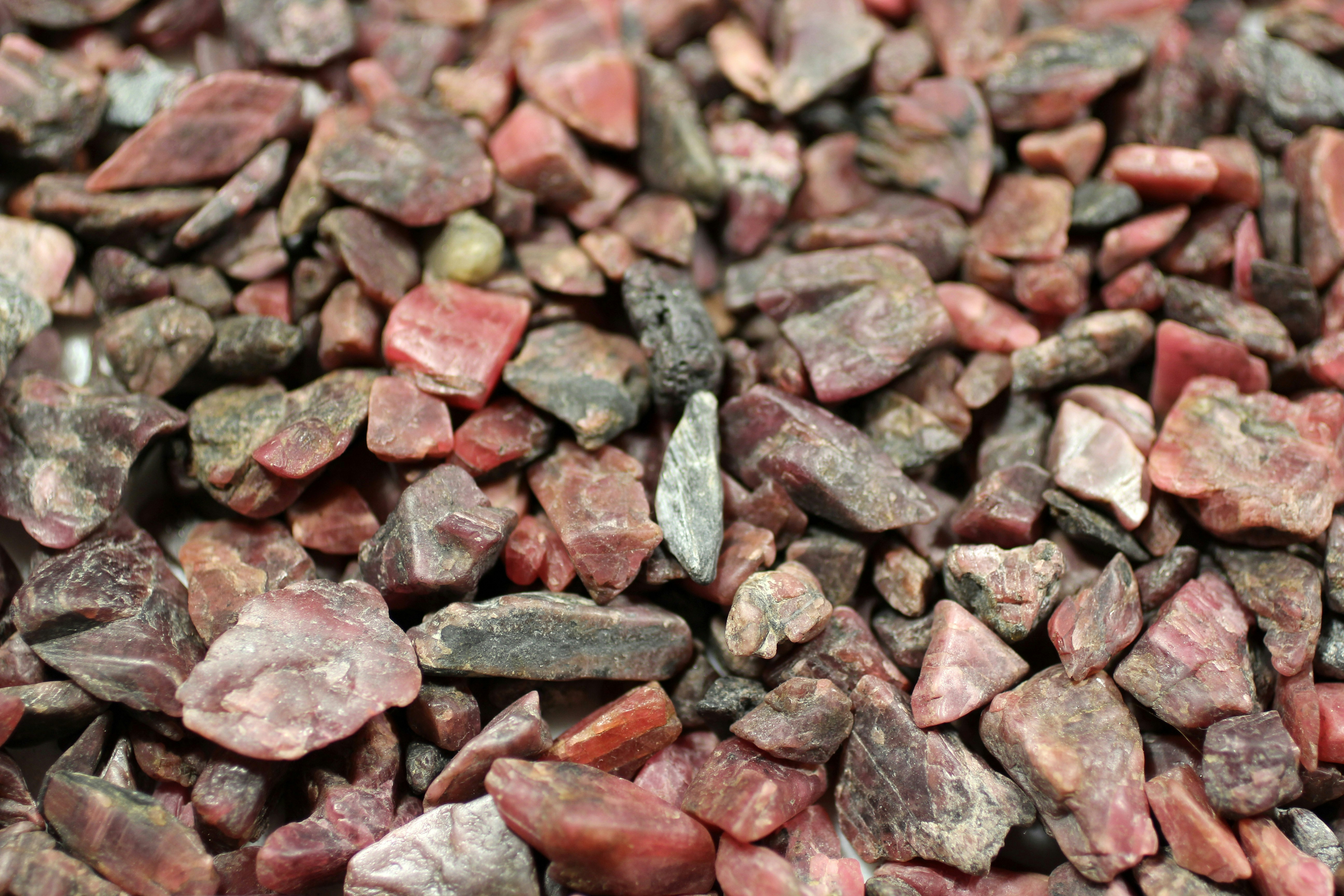 A vibrant assortment of colorful gemstones scattered across a surface, showcasing their unique shapes and hues.