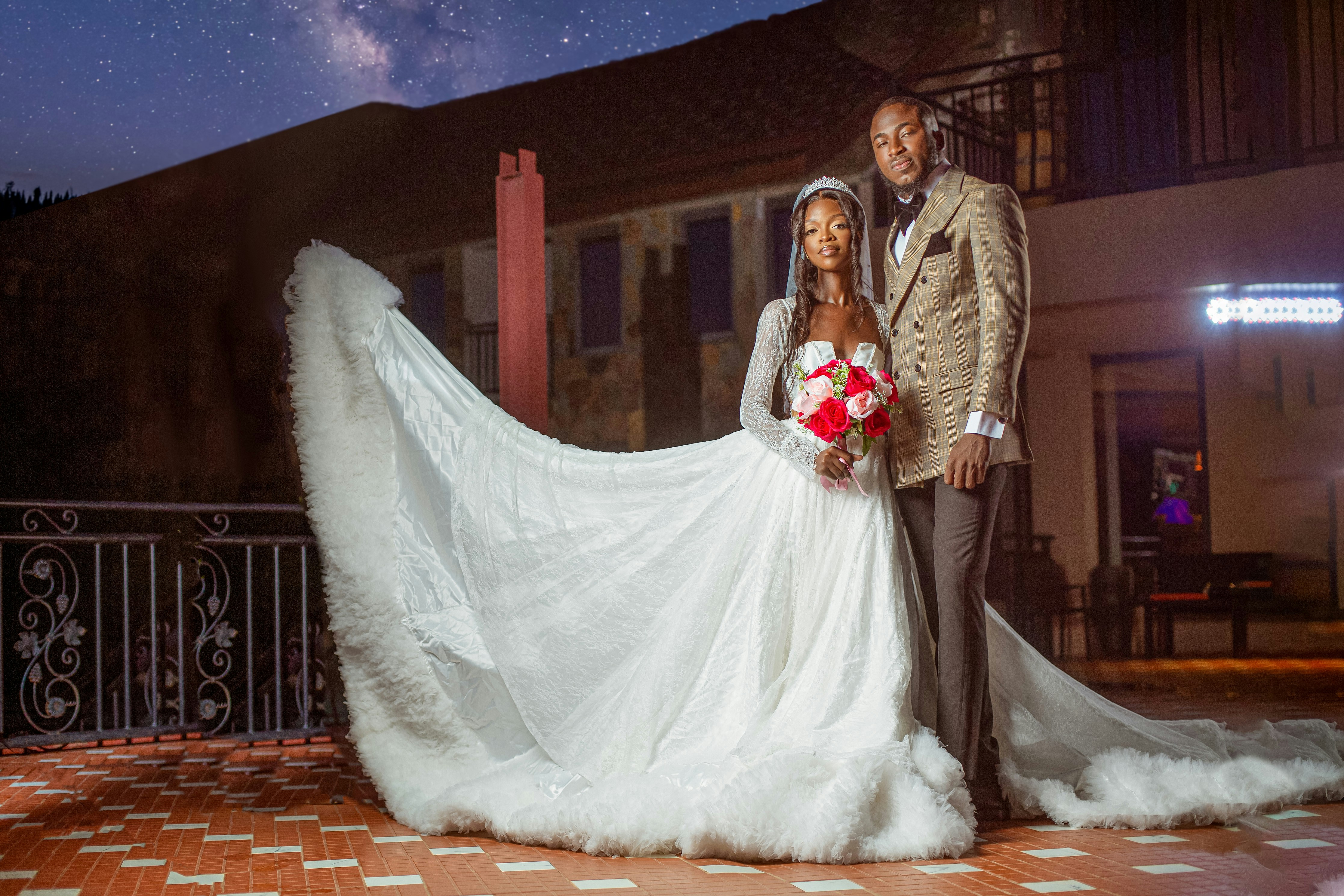 A bride and groom posing for a picture in front of a building photo ...