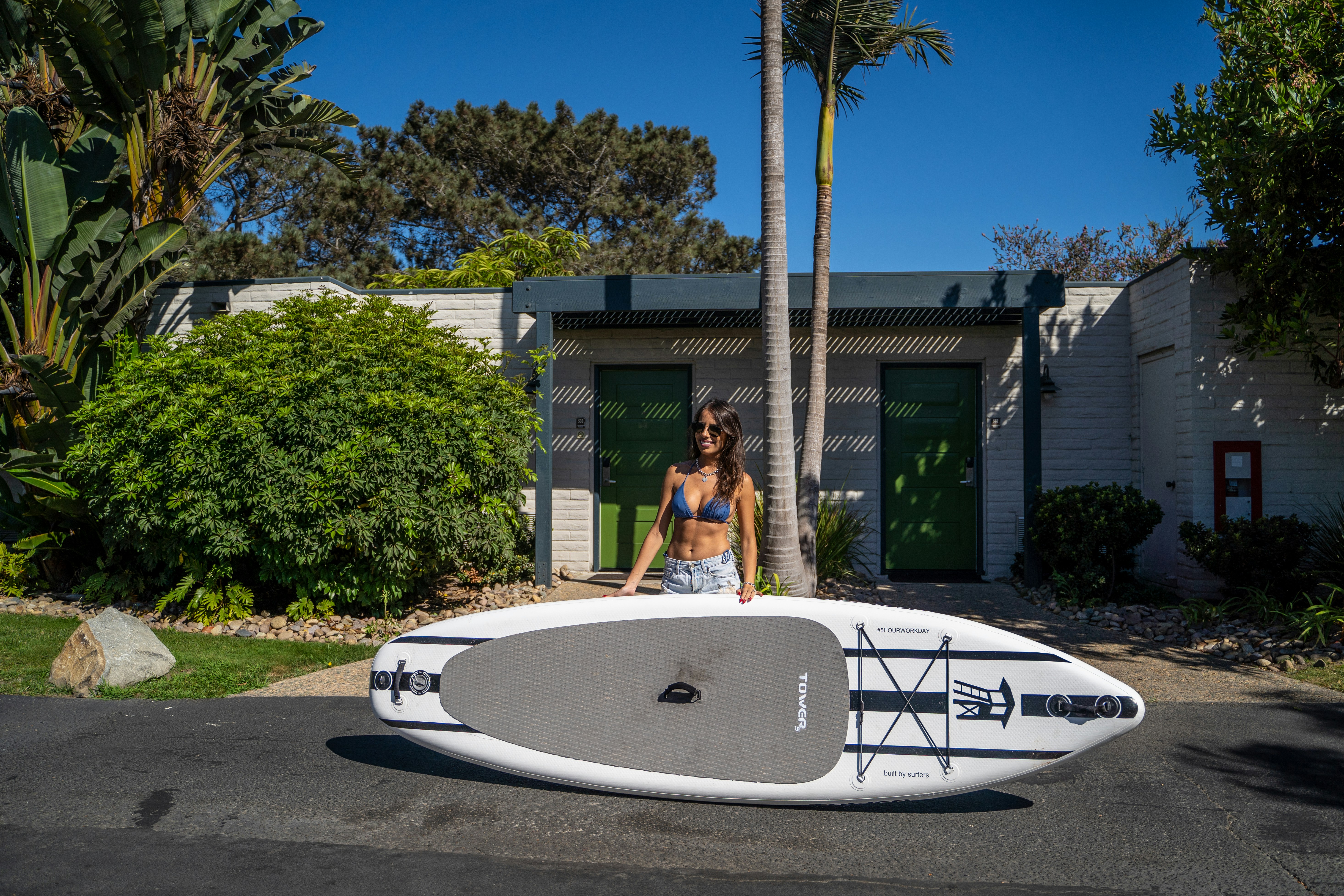 Sunlit Suburban Surf: Stand-Up Paddleboarder in a Quiet Driveway
