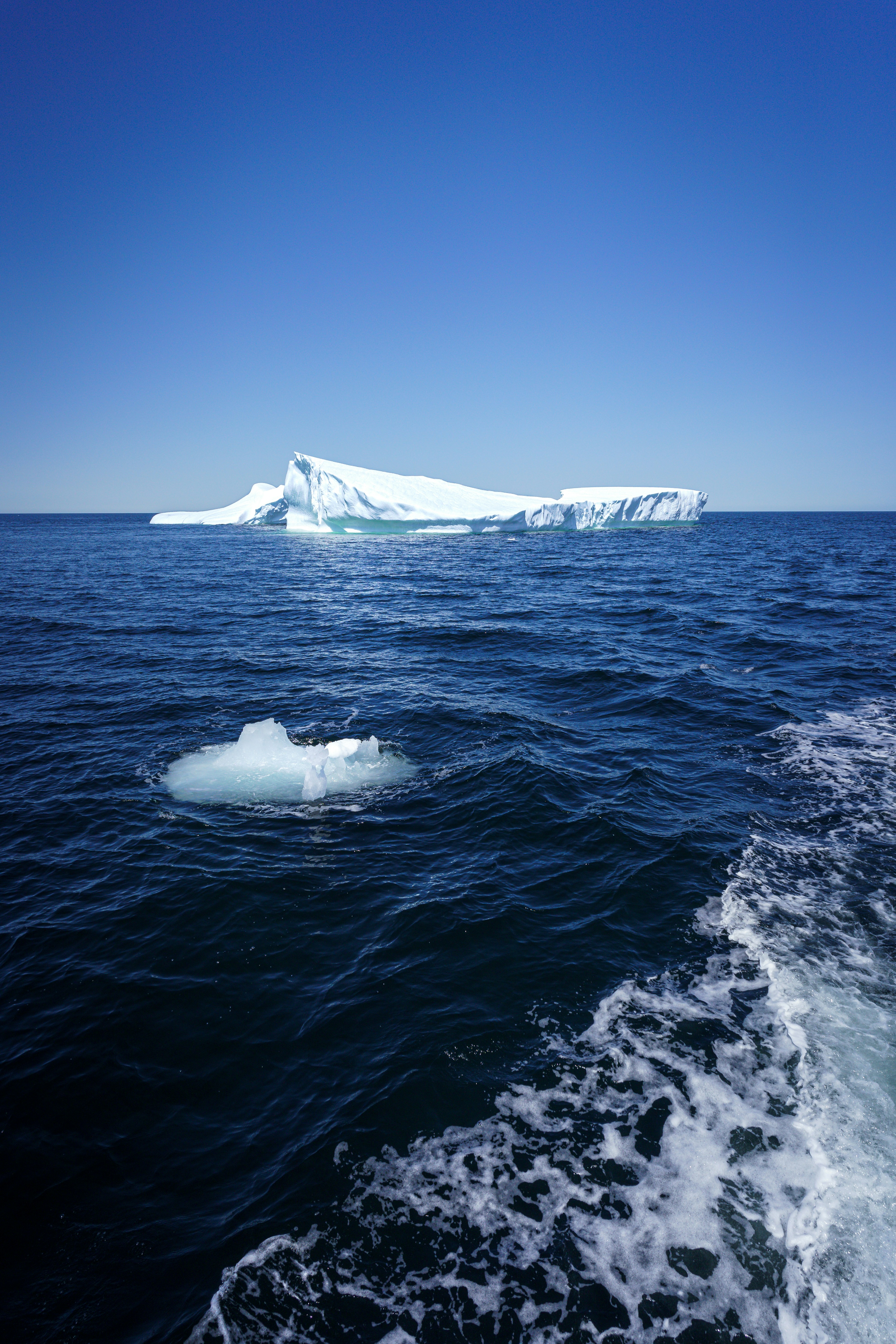 An iceberg floating in the middle of the ocean photo – Free Canada ...