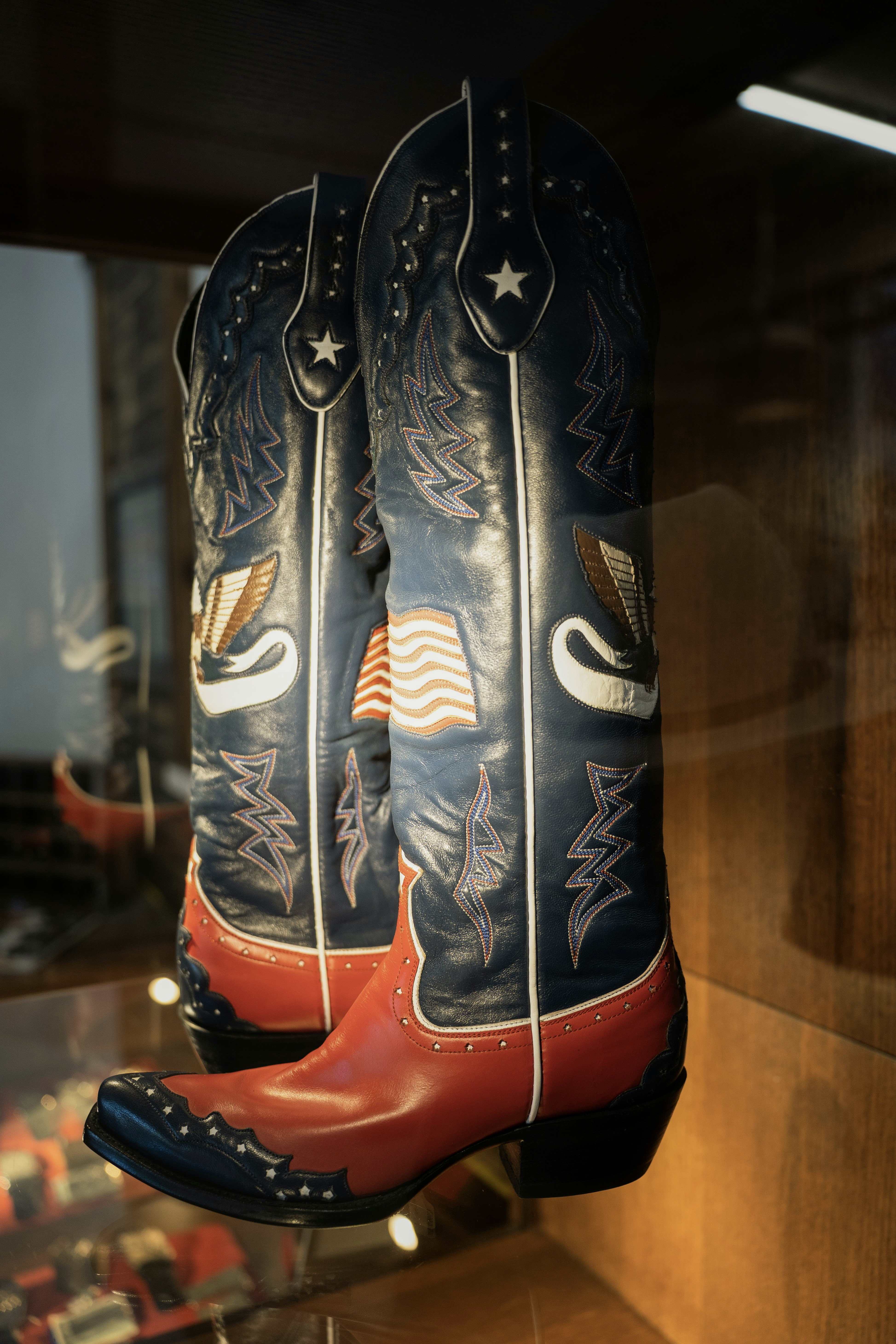 Stitched Americana: Blue Cowboy Boots in a Glass-Front Display