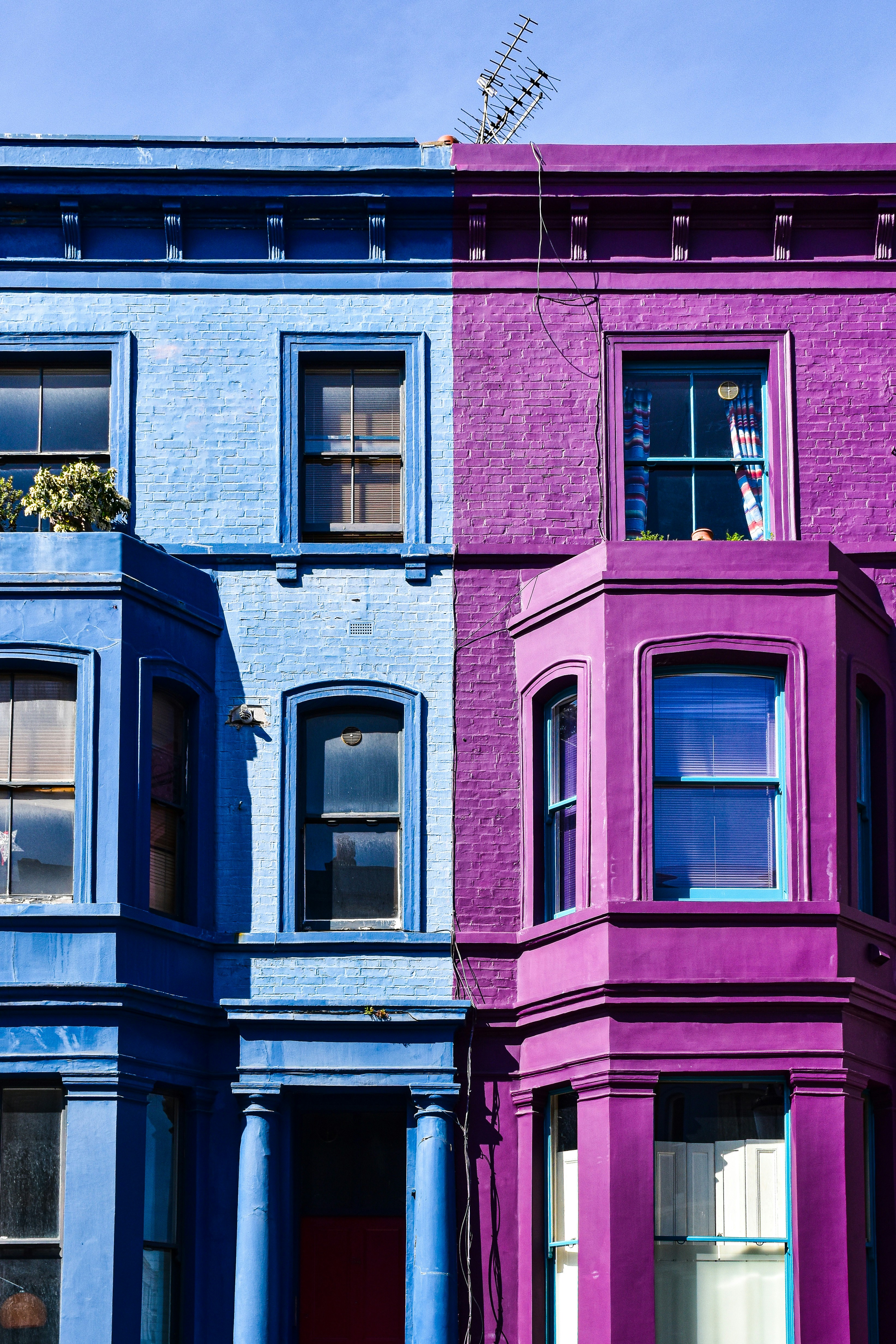 A row of multi - colored buildings with a blue sky in the background ...