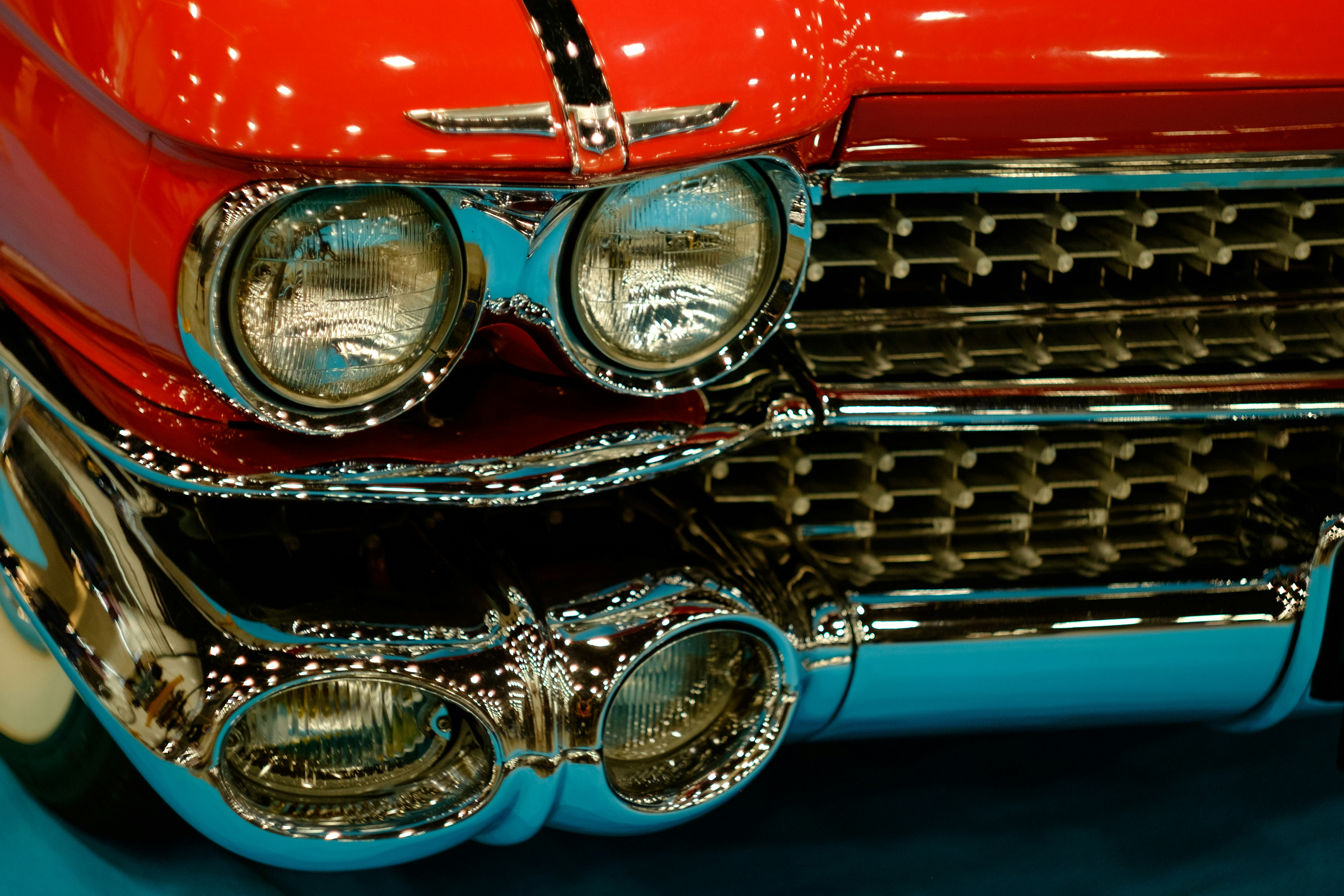 Red Prelude to Chrome: Dual Headlights Framing a Classic American Front End