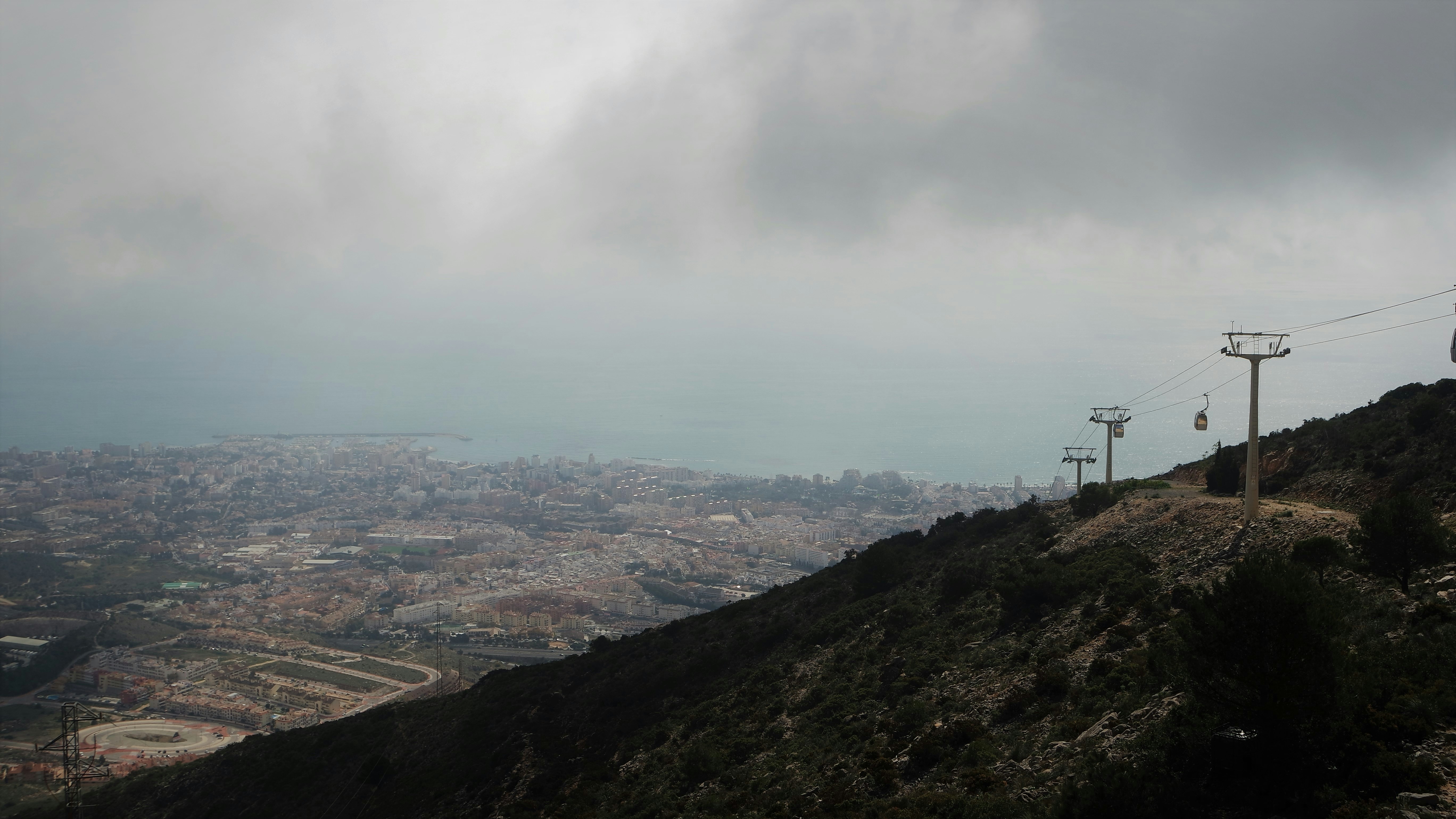 Ridge-Line Cable Cars Sweep Toward a Misty Coastal City