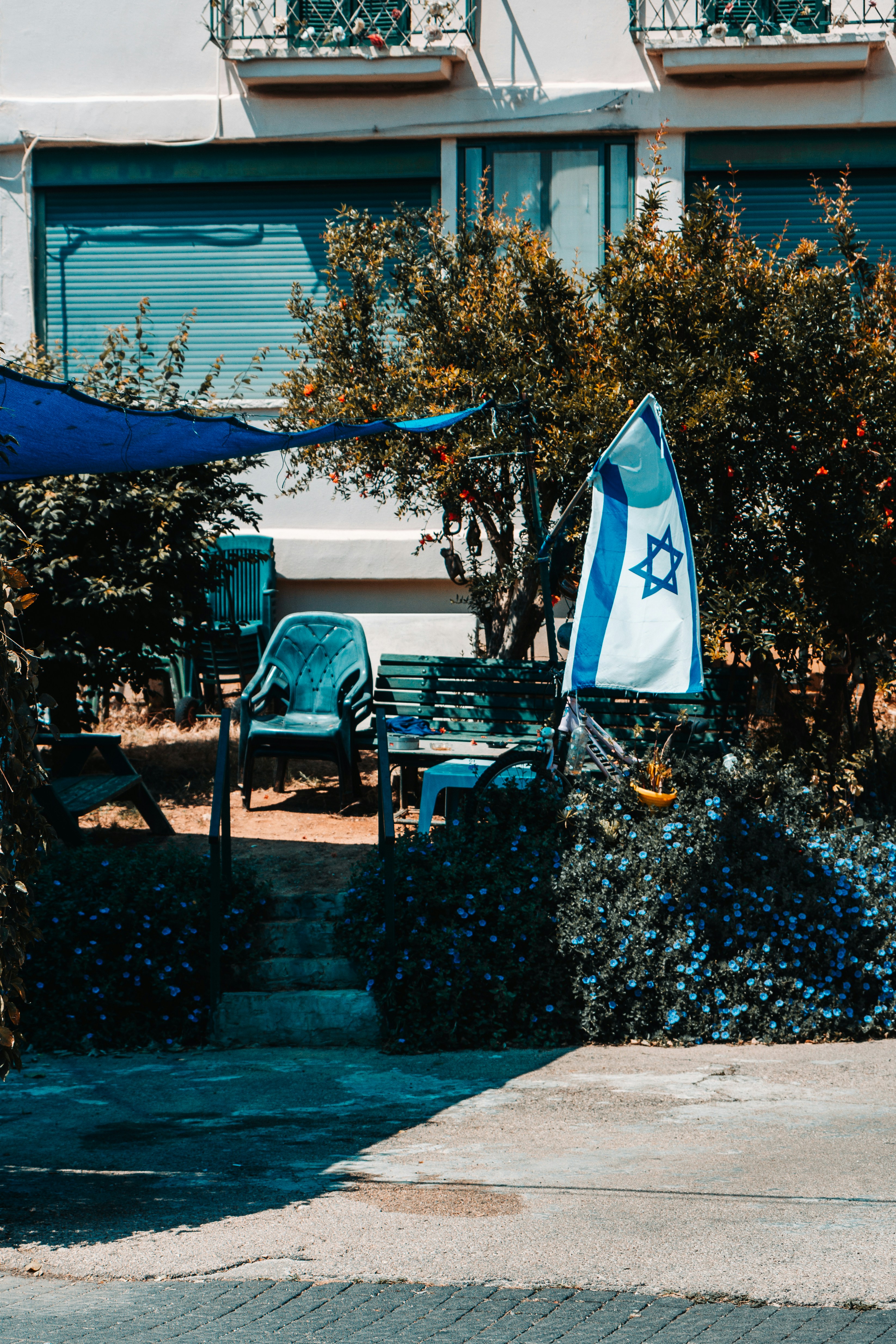 Blue-flag Oasis: Outdoor Seating Behind a Mediterranean Row