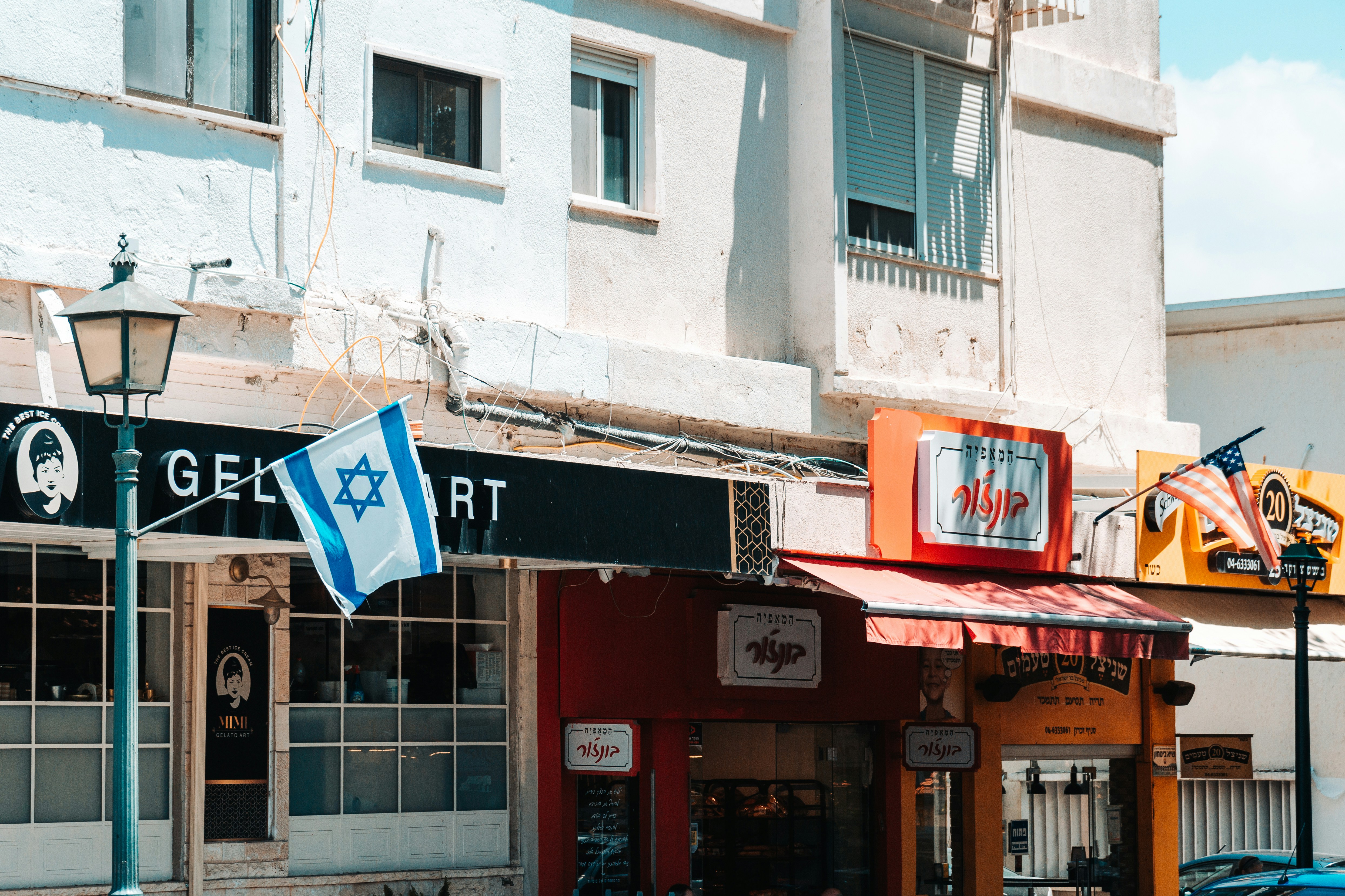 A street corner with a few shops on the corner photo – Free Car Image ...