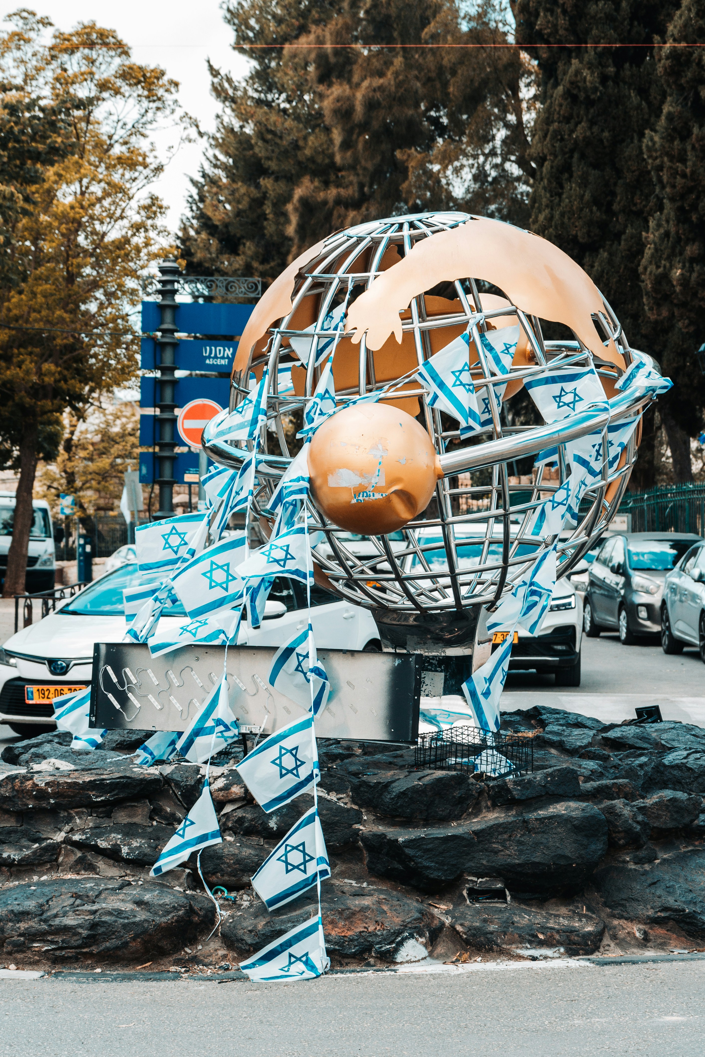 Globe of Flags: A Neon-Blue Star of David Sculpture in Urban Roundabout