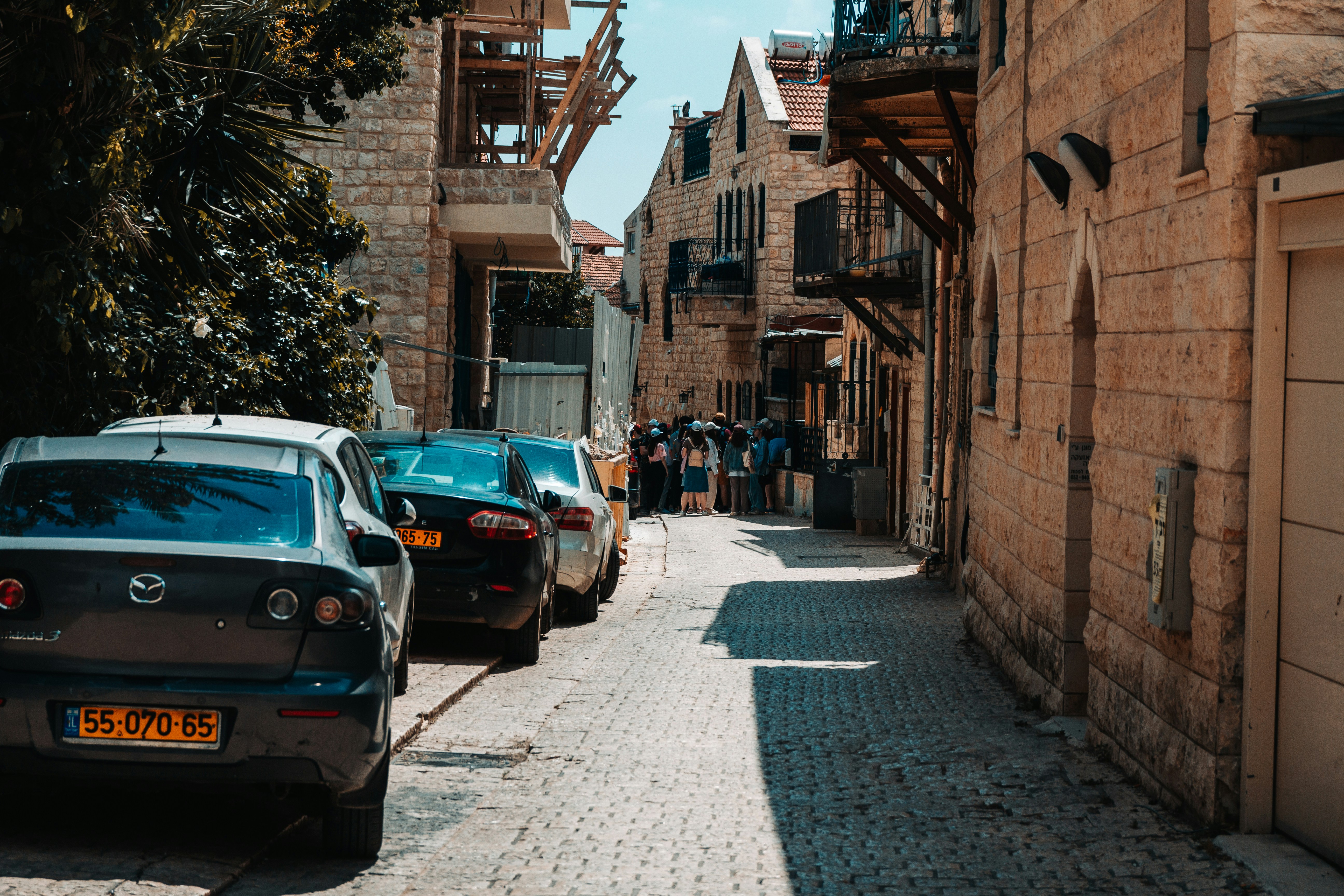 A street lined with parked cars next to tall buildings photo – Free ...
