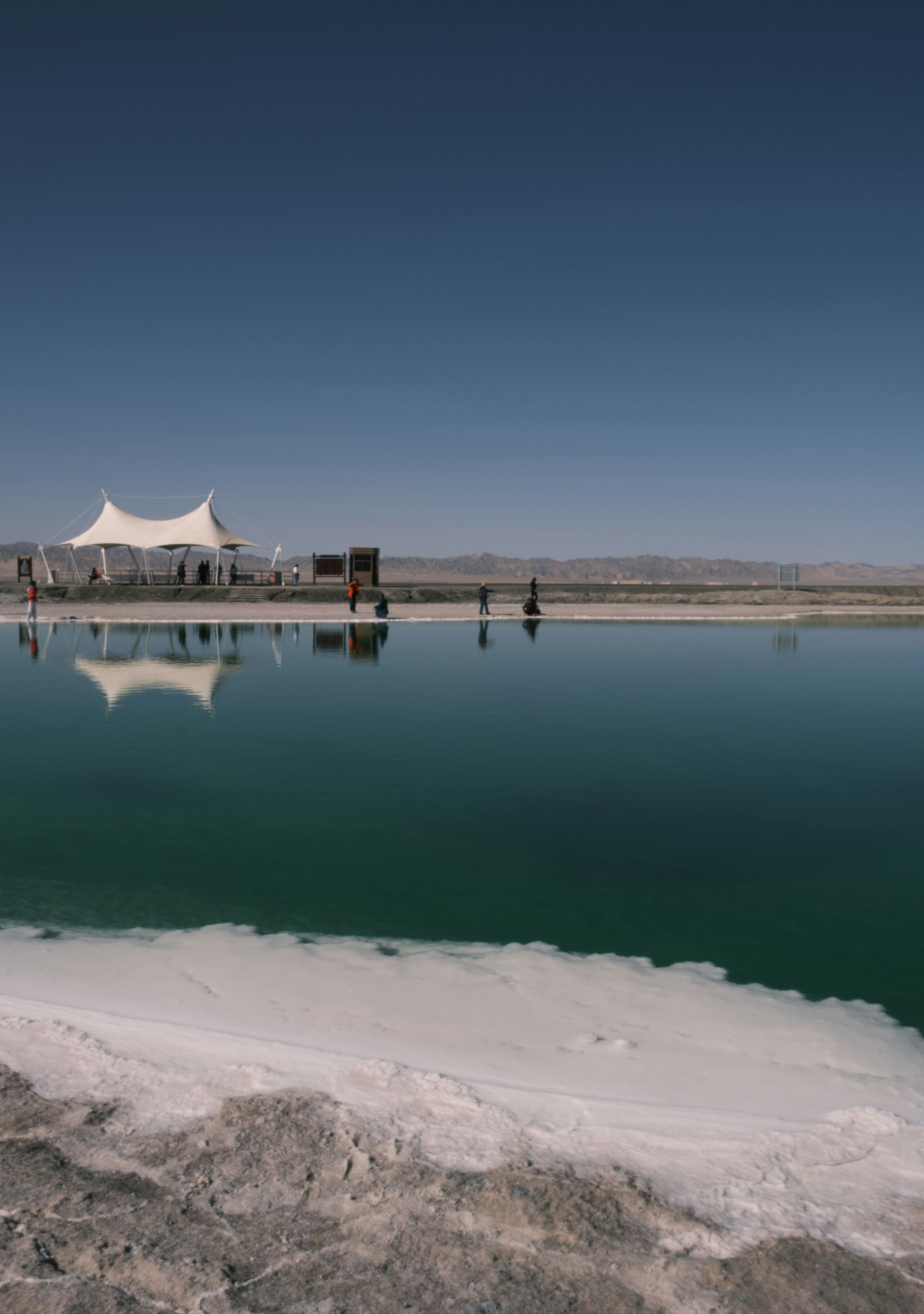 White Canopy Over a Glassy Salt Lake: Reflections and Desert Horizon