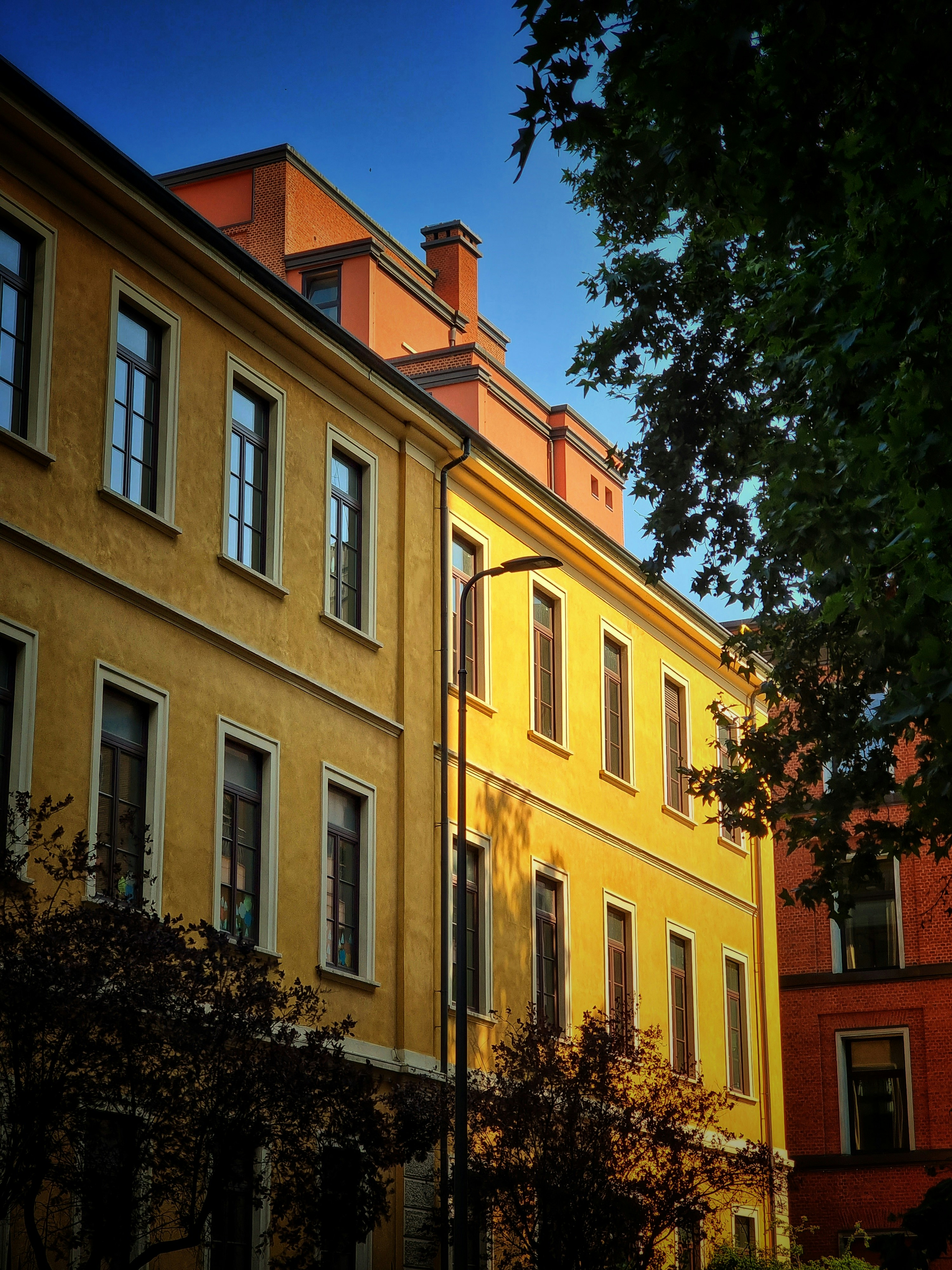 Un bâtiment jaune avec des fenêtres et un lampadaire devant lui photo ...