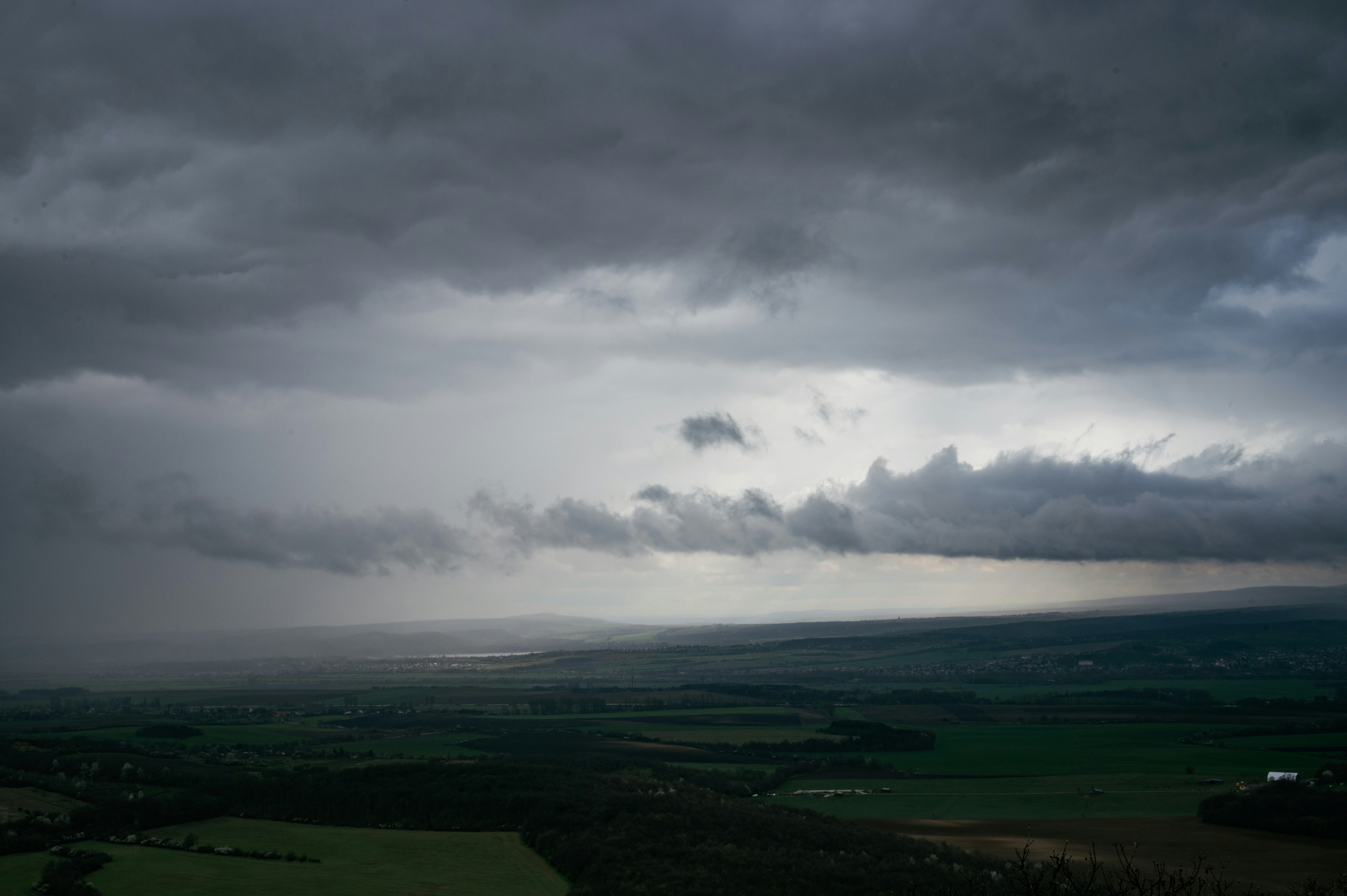 A storm moving through the sky over a green field photo – Free Forest ...