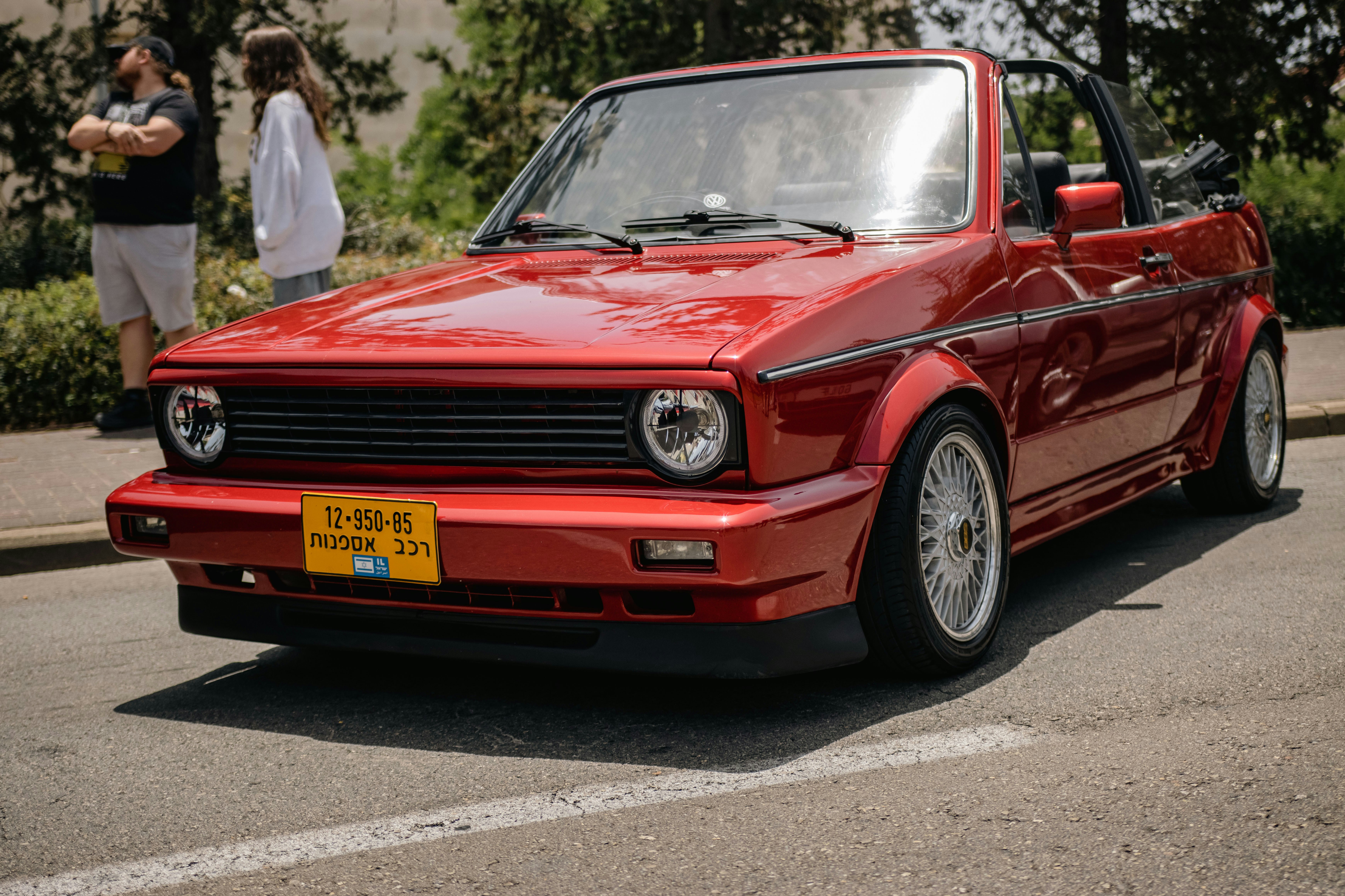 Bright Red Classic Convertible Gliding Across a Parking Lot
