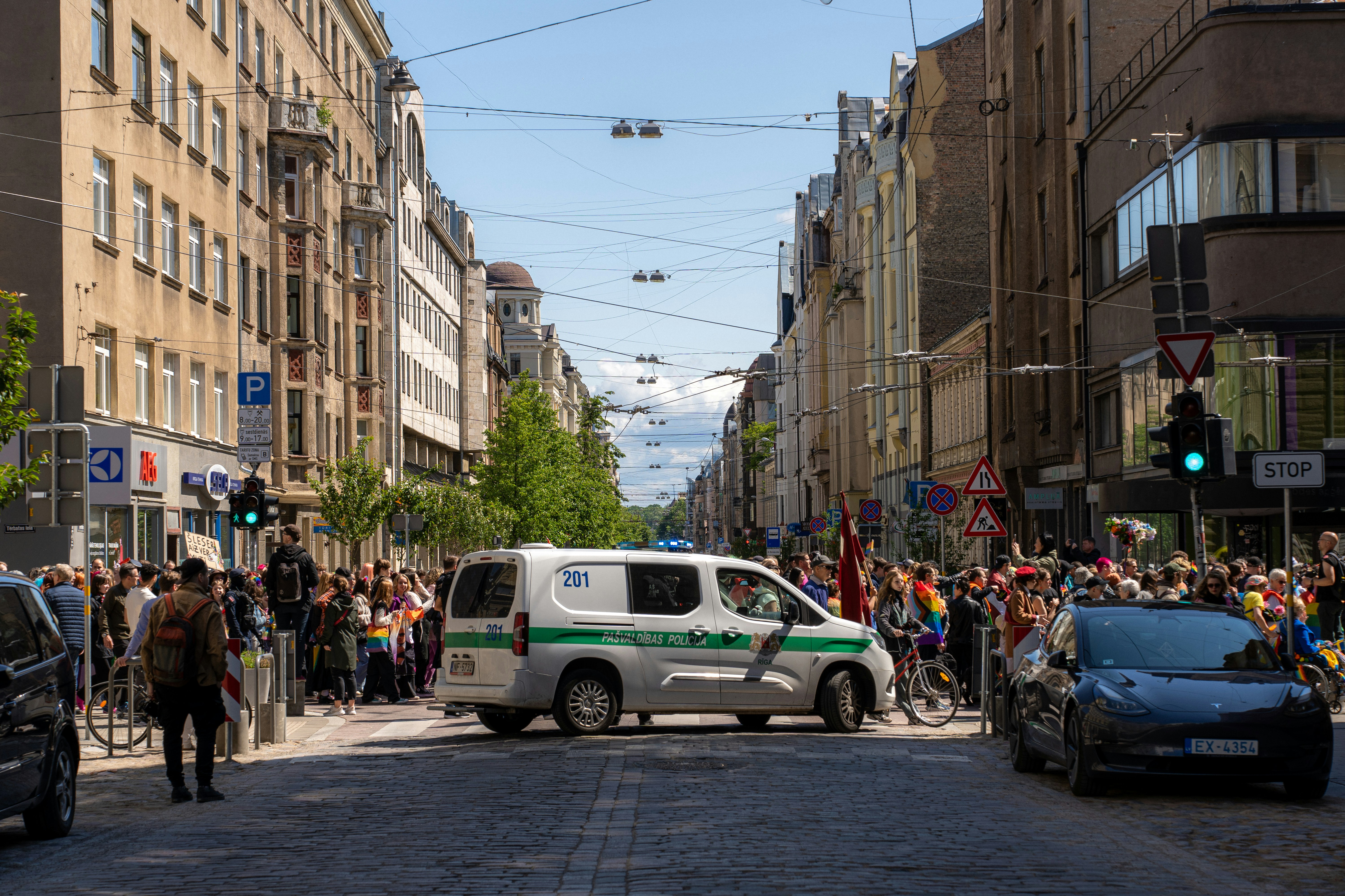 Crosswalk Convergence: A White Van Halts the City's Pulse