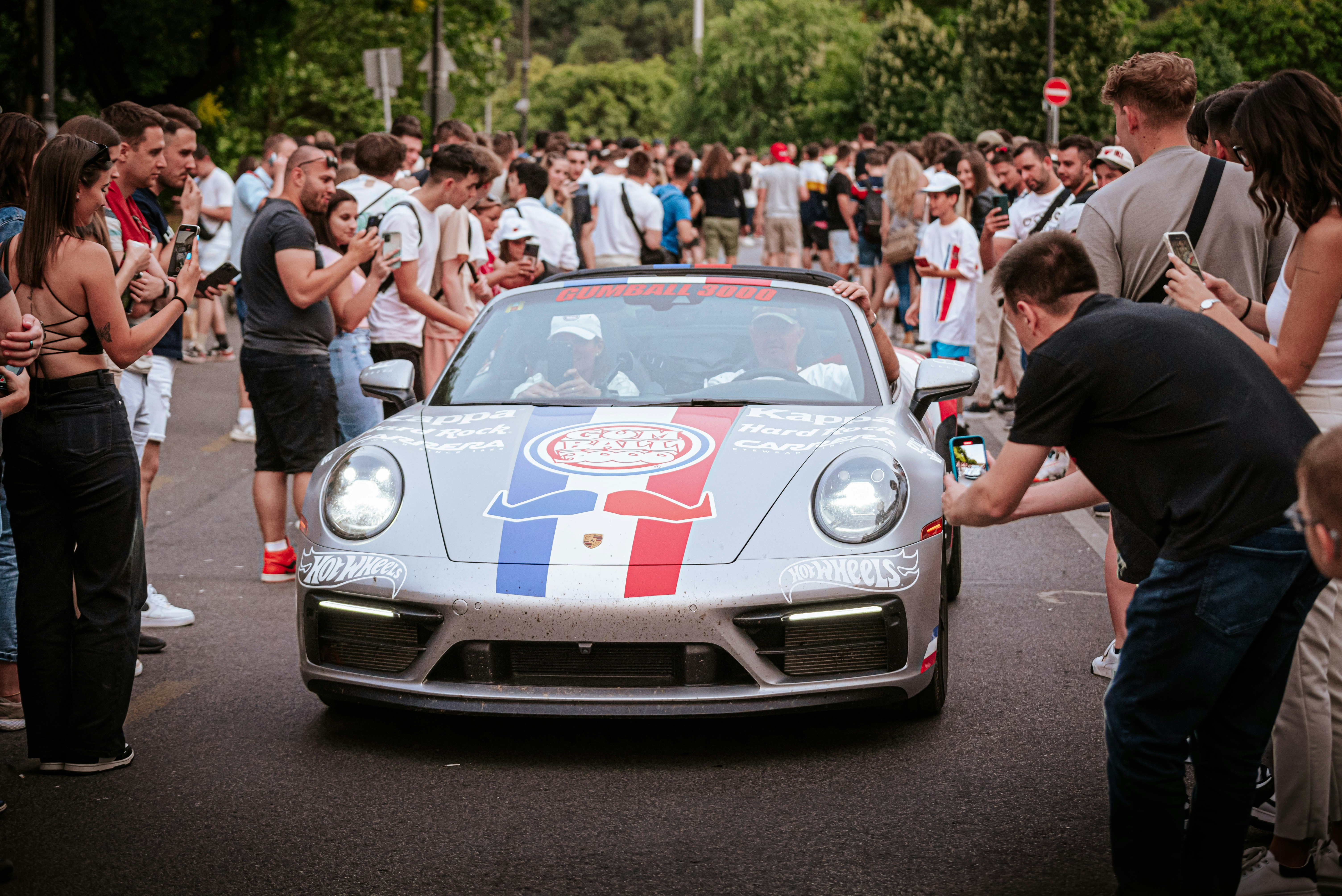 A group of people standing around a car photo – Free Hungary Image on ...