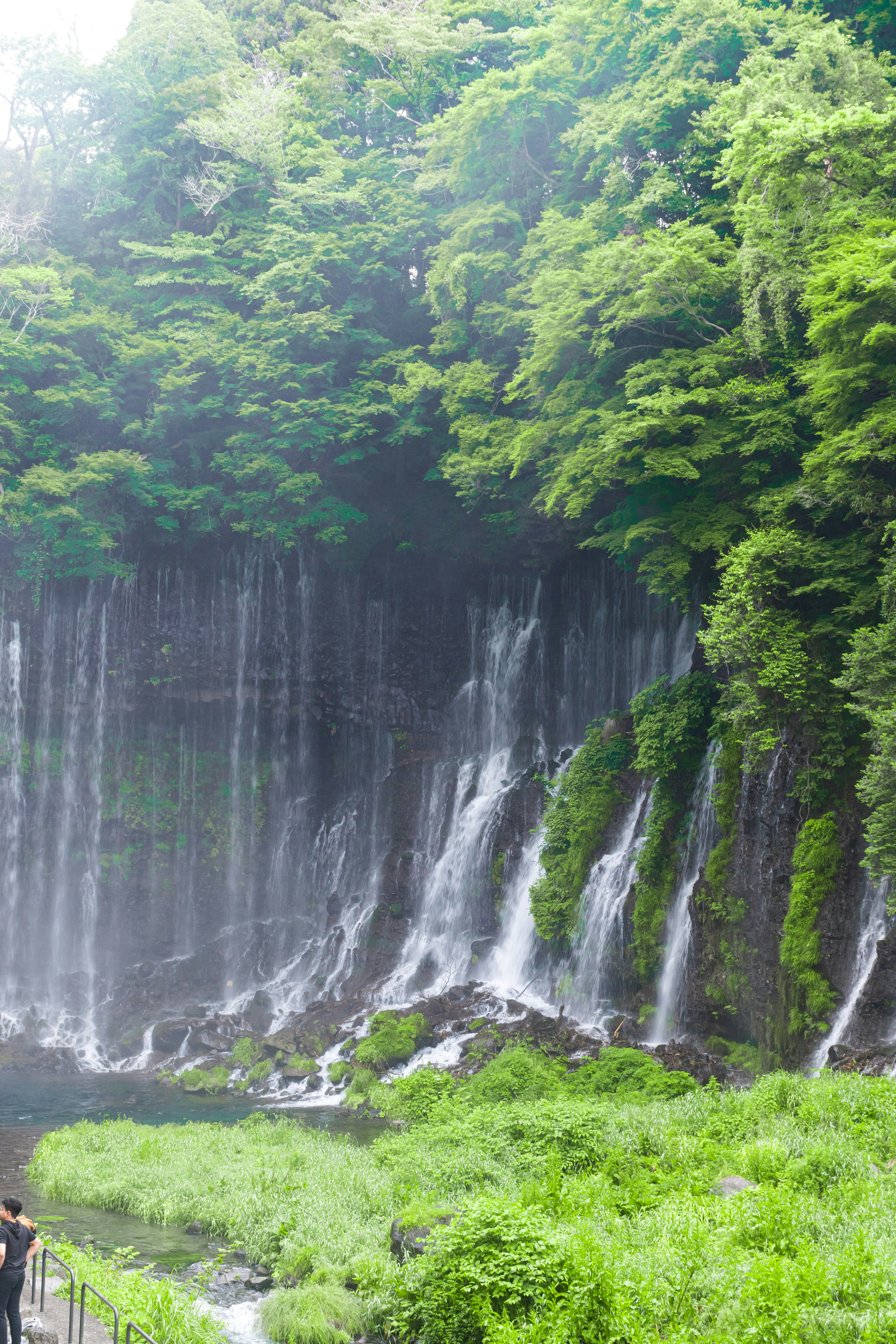 Un groupe de personnes debout devant une cascade photo – Image gratuite ...