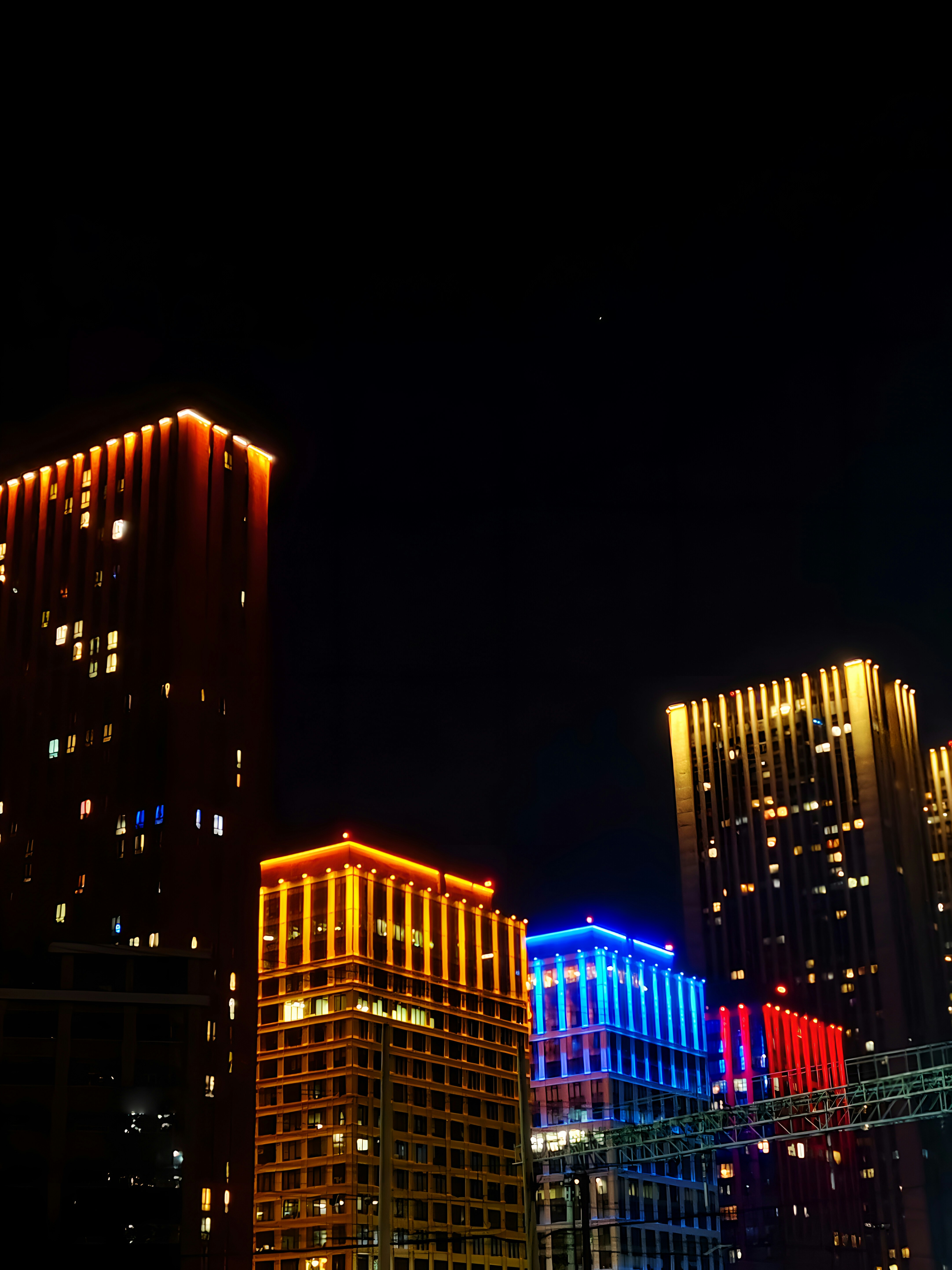 A group of tall buildings lit up at night photo – Free Skyscraper Image ...