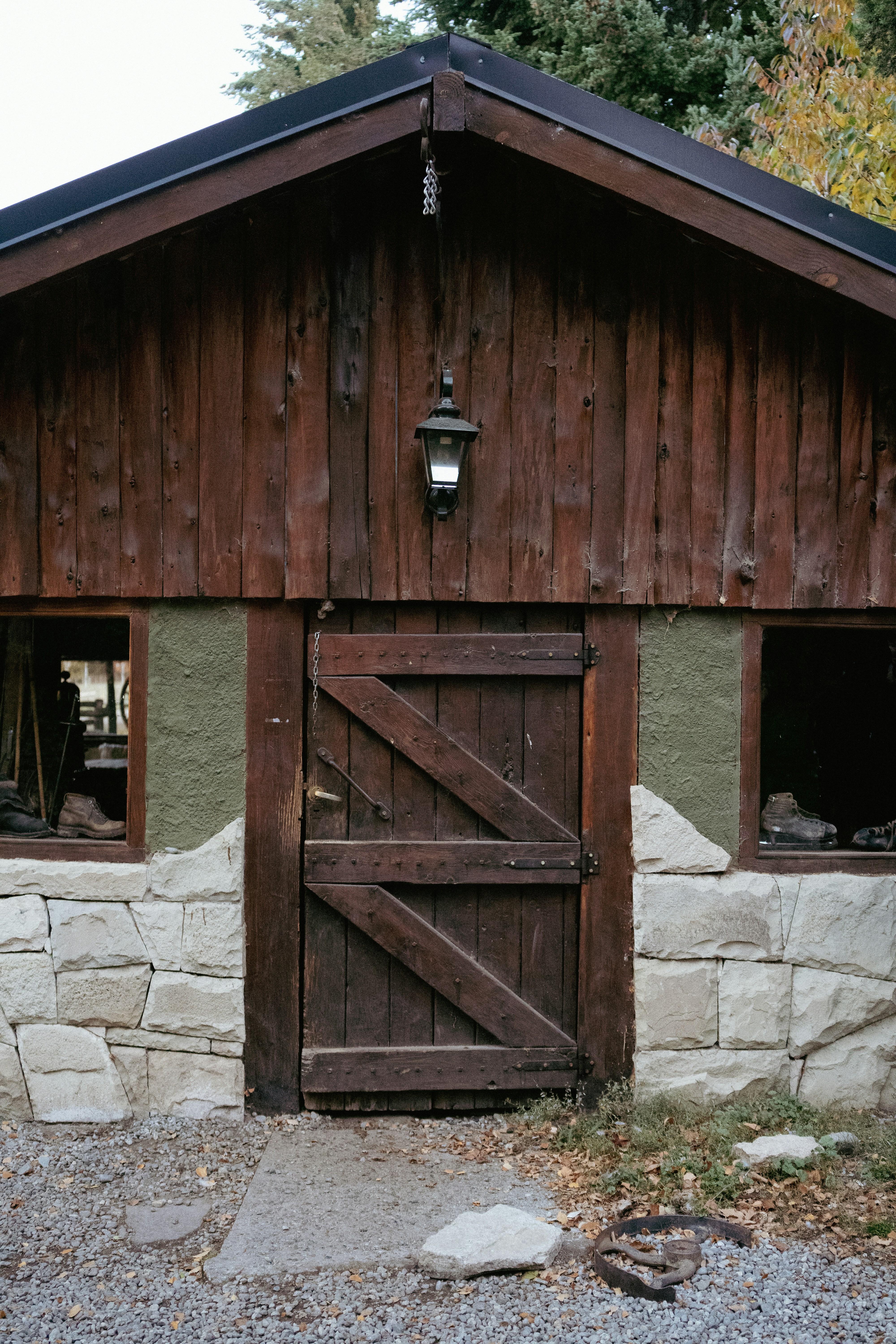 Lamplight at the Gate: Weathered Barn Door Framed by Stone and Wood
