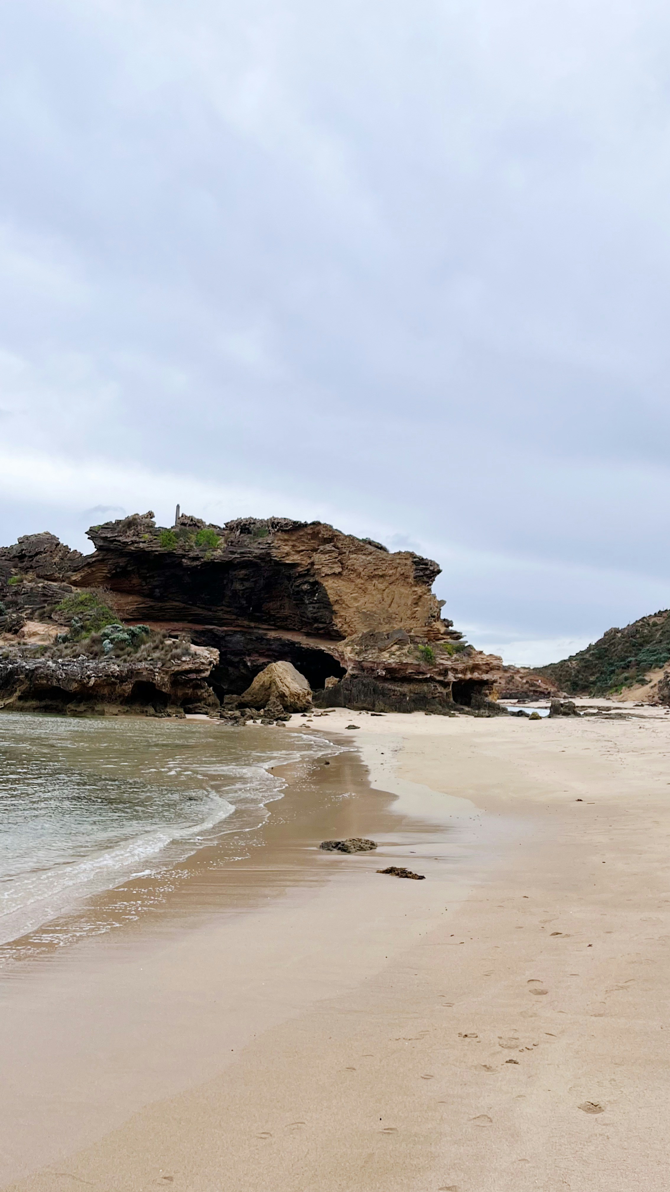 Weather-worn Rock Overhang Embracing a Secluded Beach