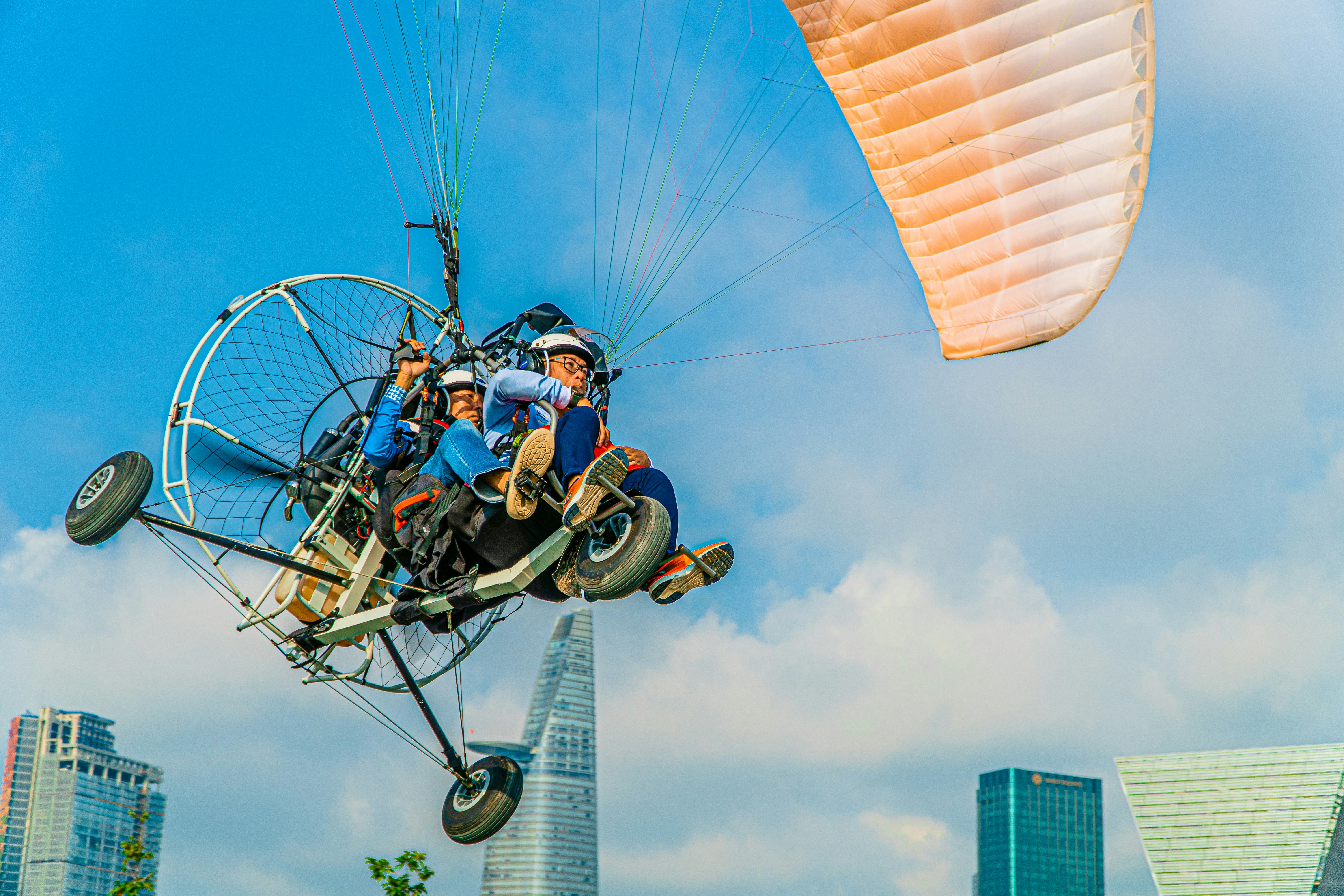 Orange-Wing Paramotor Trike Over Downtown Skyline