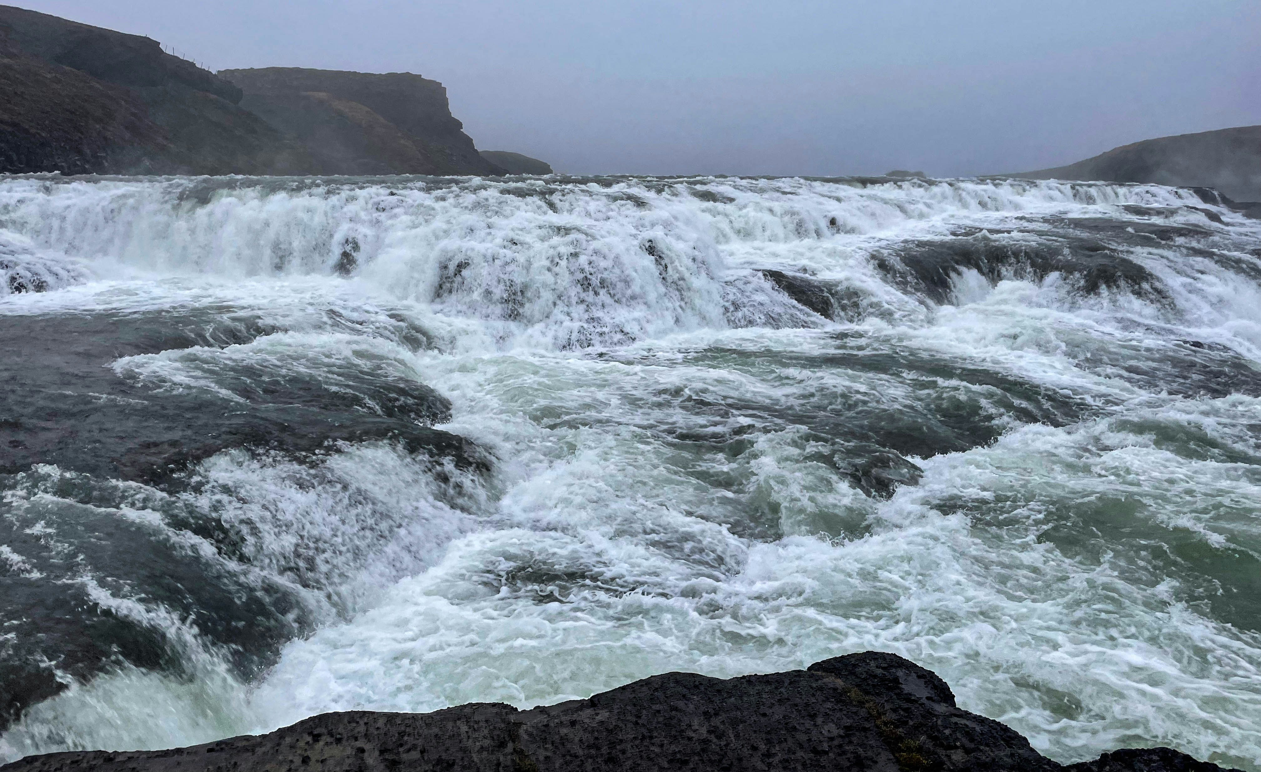 Rushing Coastal Cascade Between Weathered Cliffs
