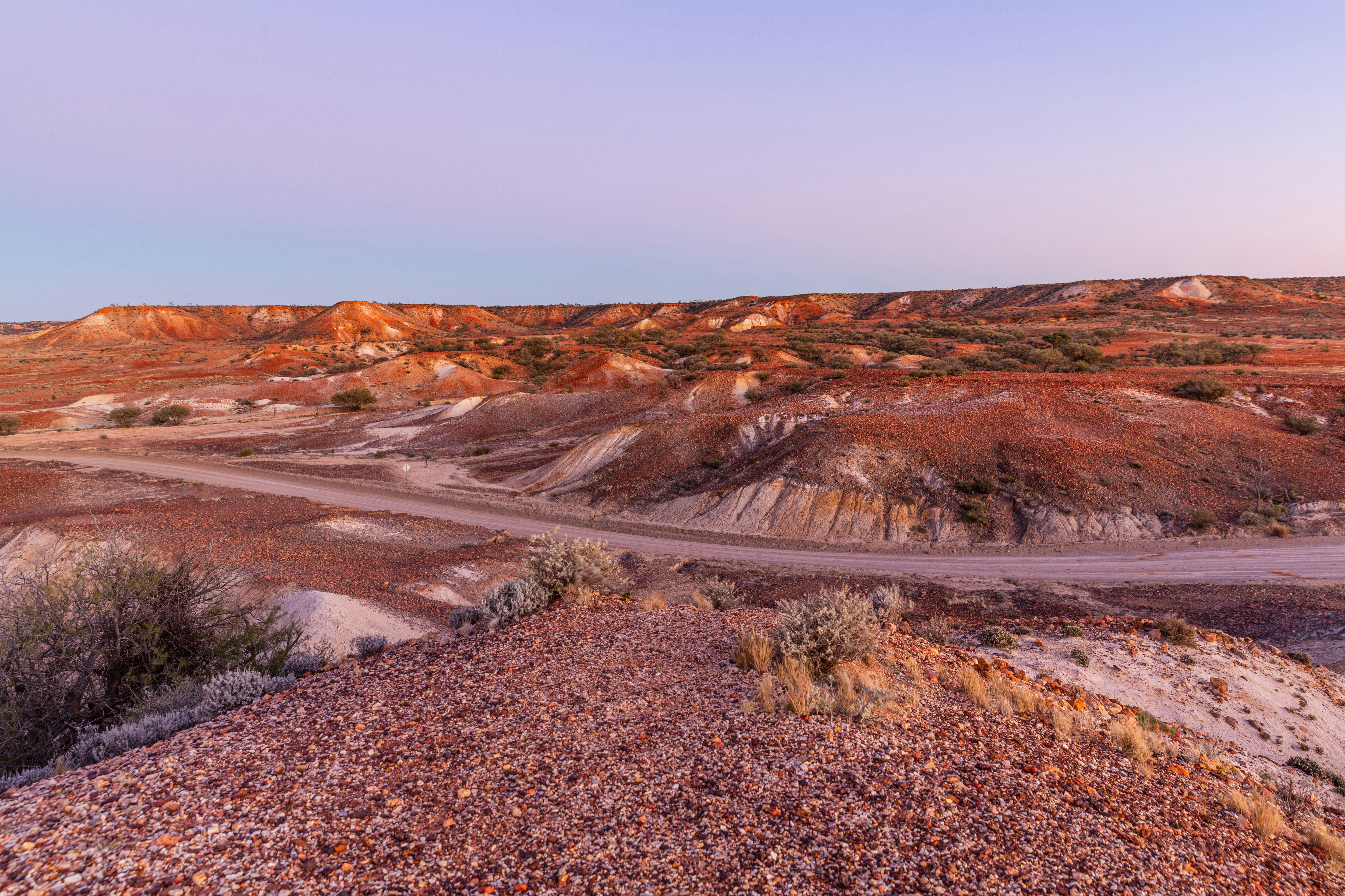 Twilight Over Painted Badlands: A Winding Gravel Ribbon Through Ember Hills